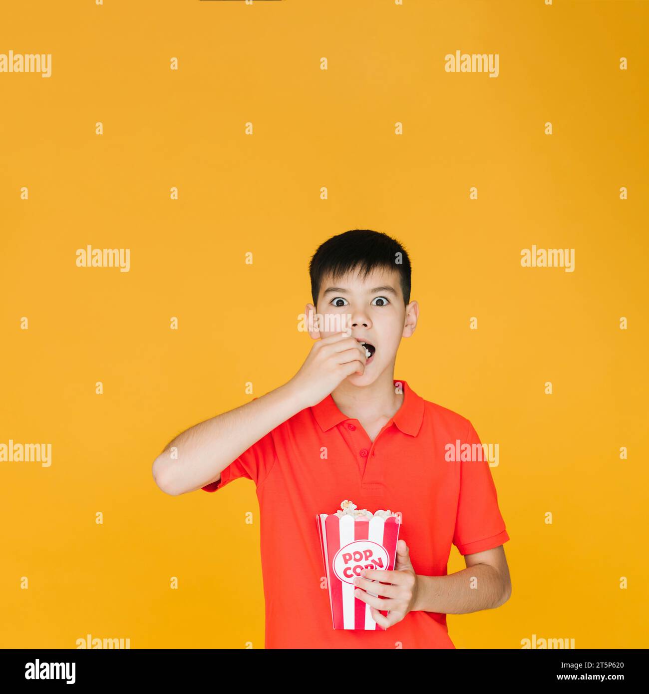 Shocked kid eating popcorn Stock Photo - Alamy