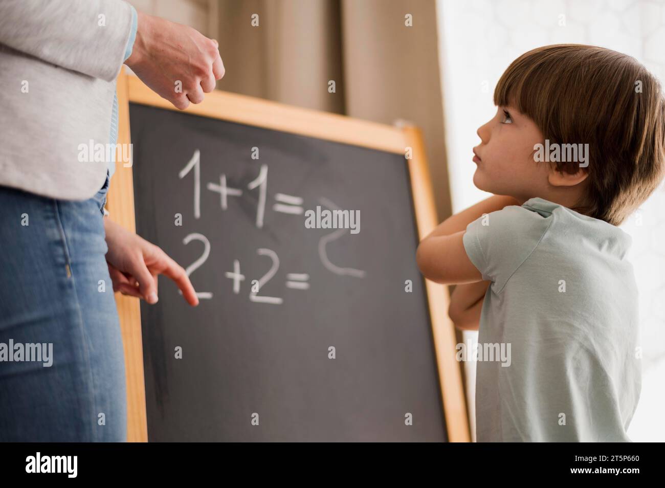 Side view child home being taught mathematics Stock Photo - Alamy