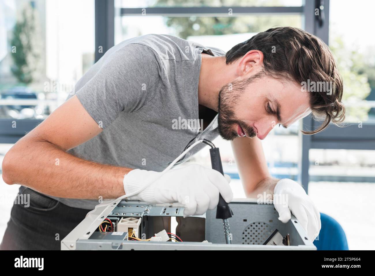 Side view young male technician working broken computer Stock Photo - Alamy