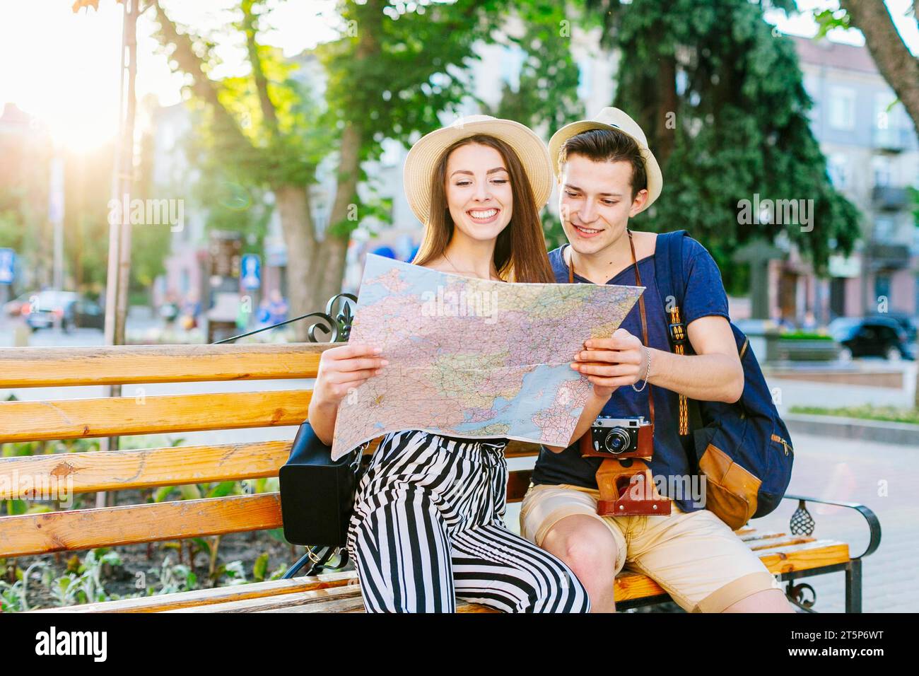 Tourist couple bench looking map Stock Photo - Alamy