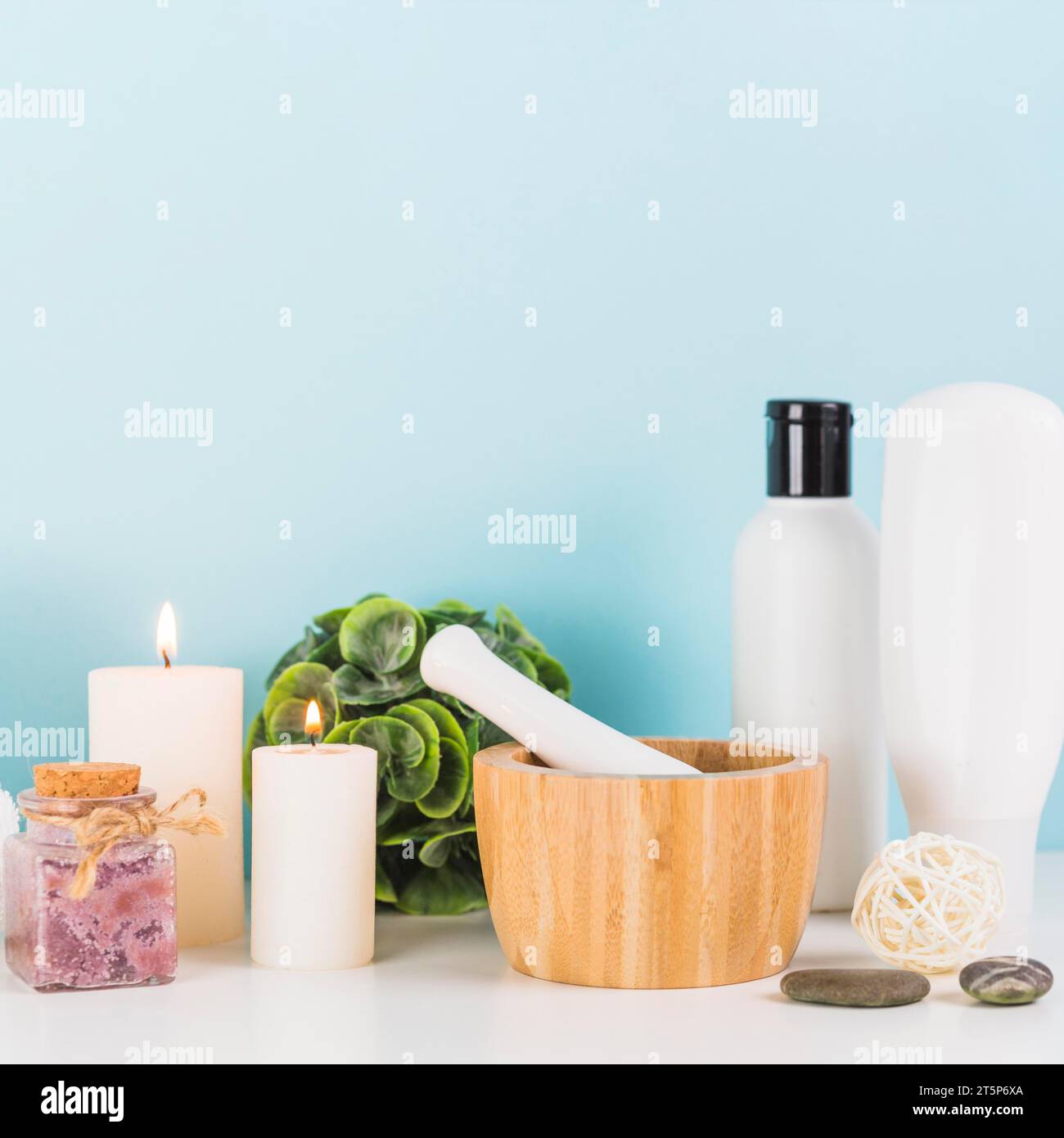 Various spa products with illuminated candles mortar pestle white ...