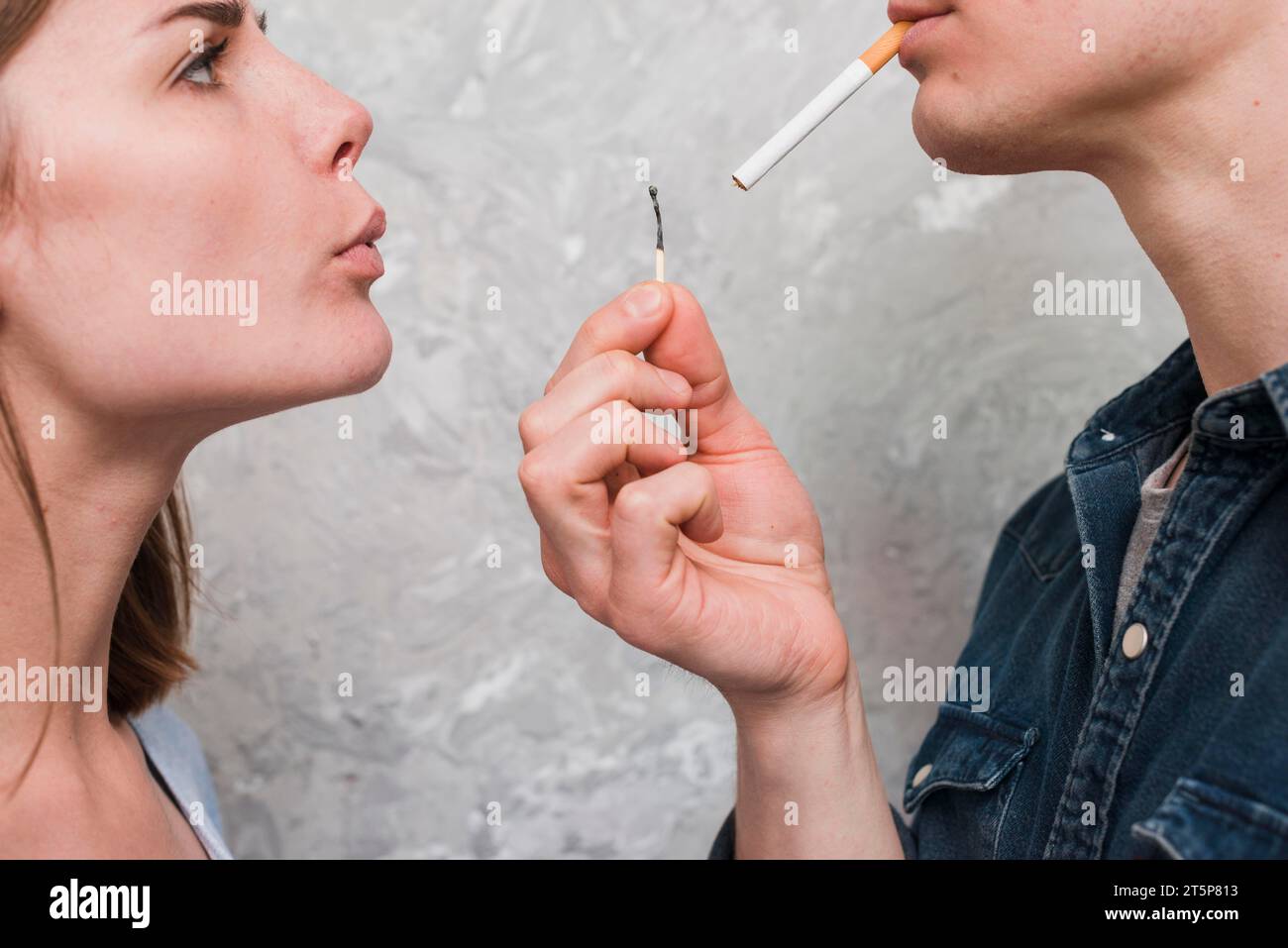 Close up woman blowing match stick hold by her boyfriend carrying ...
