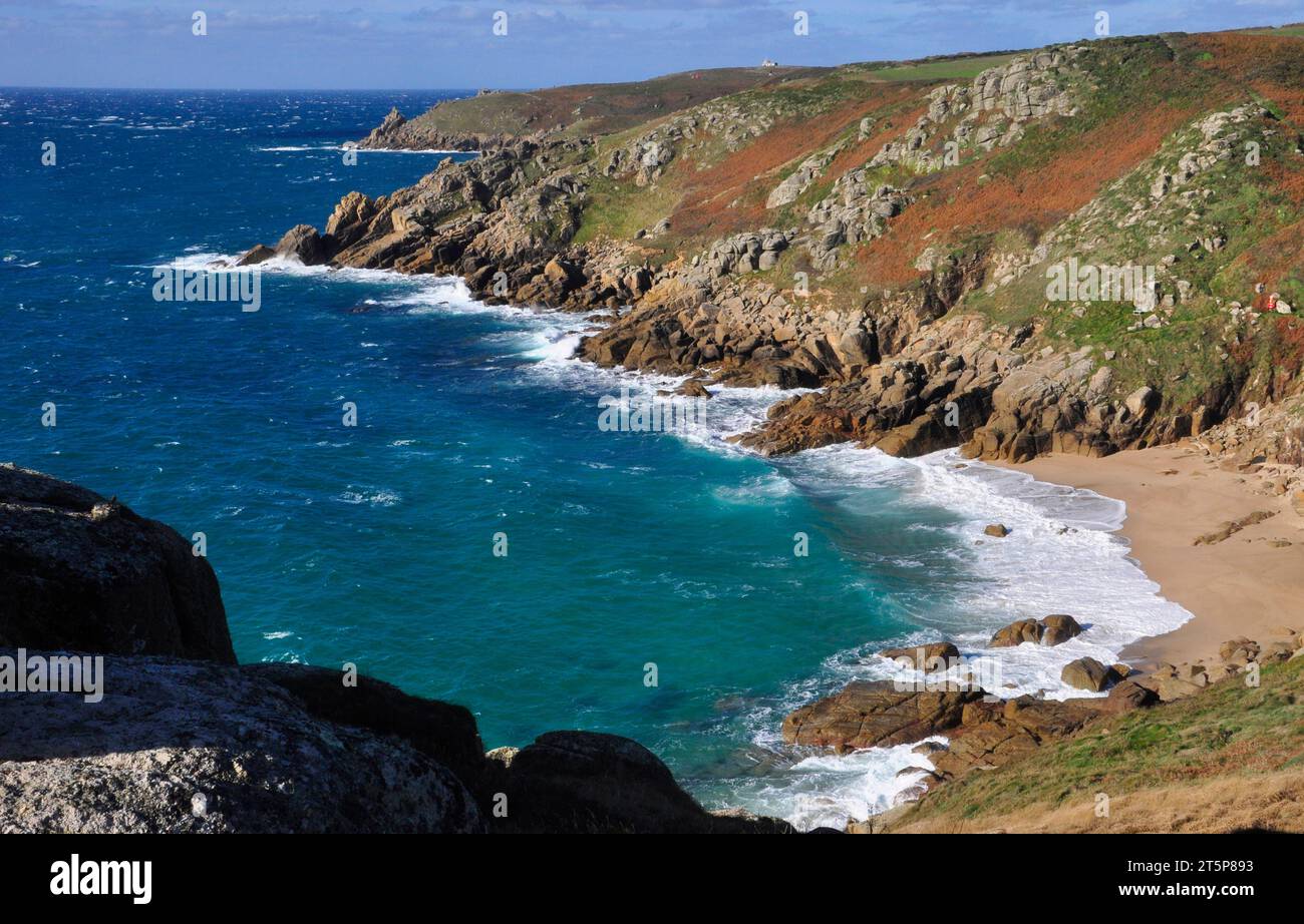 Gently sloping cliffs to the bright blue sea with sandy Porth Chapel ...