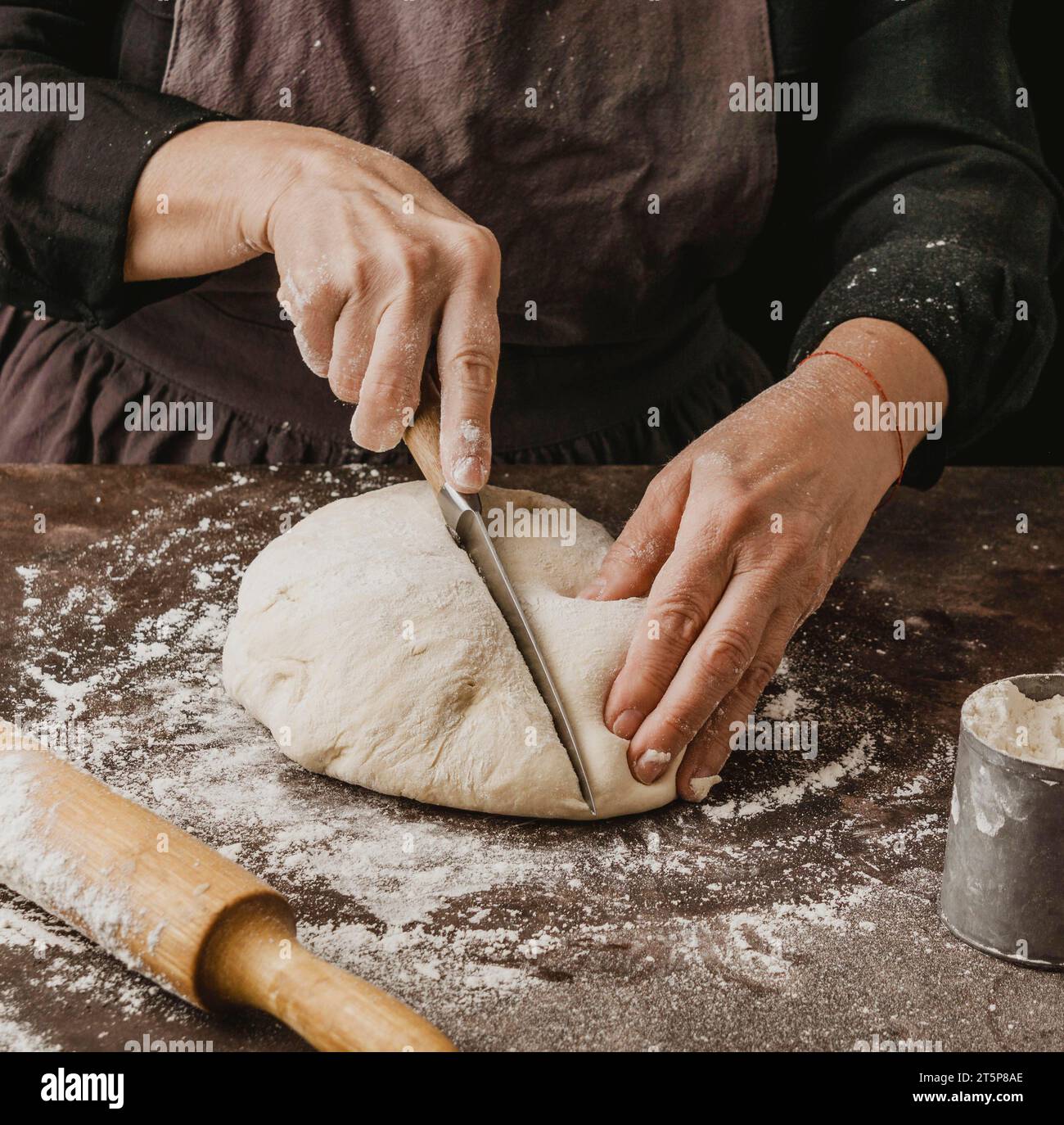 Female chef cutting pizza dough half Stock Photo - Alamy