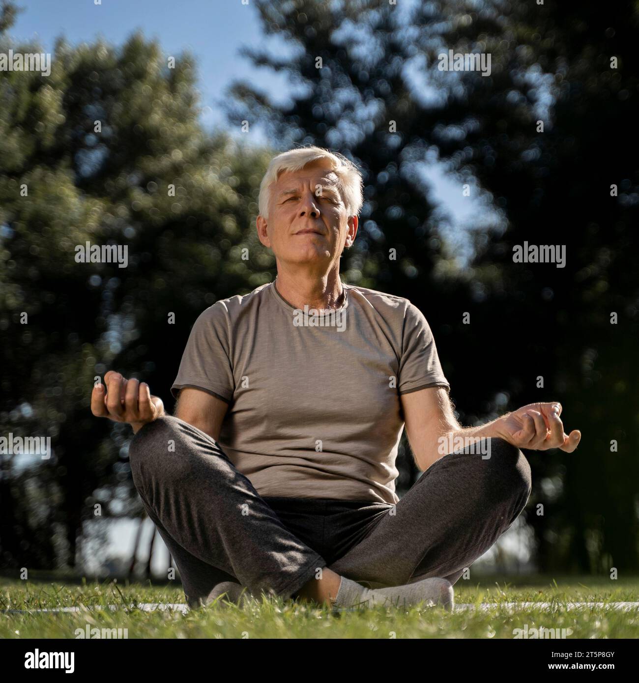 Front View Older Man Lotus Position Outdoors During Yoga Stock Photo Front View Older Man Lotus Position Outdoors During Yoga Stock Photo