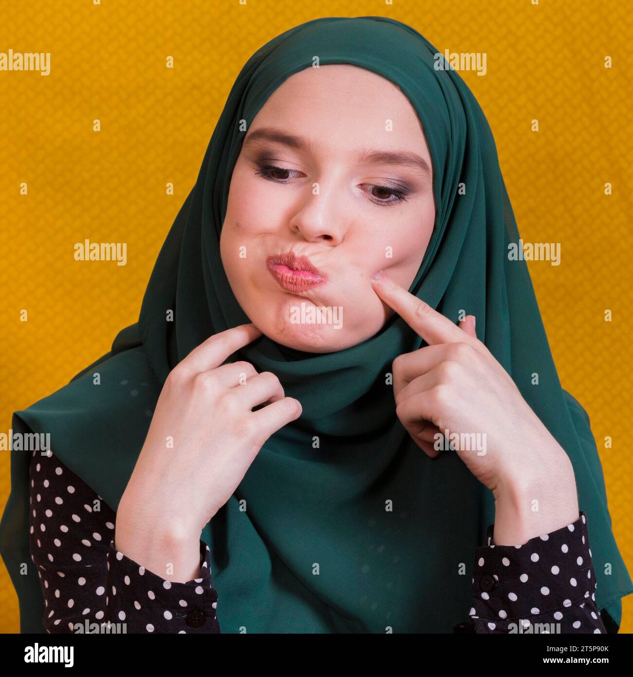Islamic woman making funny face against yellow backdrop Stock Photo - Alamy
