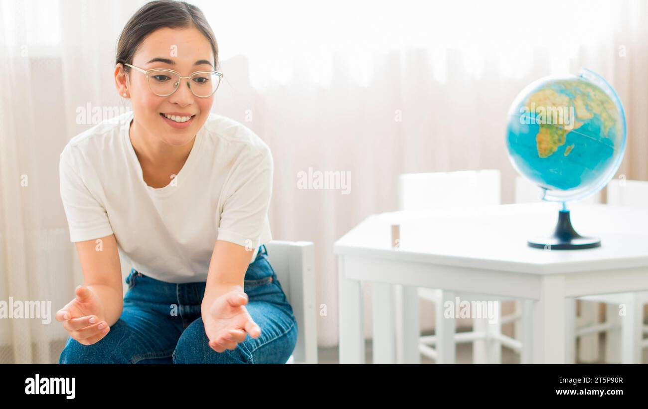 Kindergarten teacher explaining earth globe Stock Photo - Alamy
