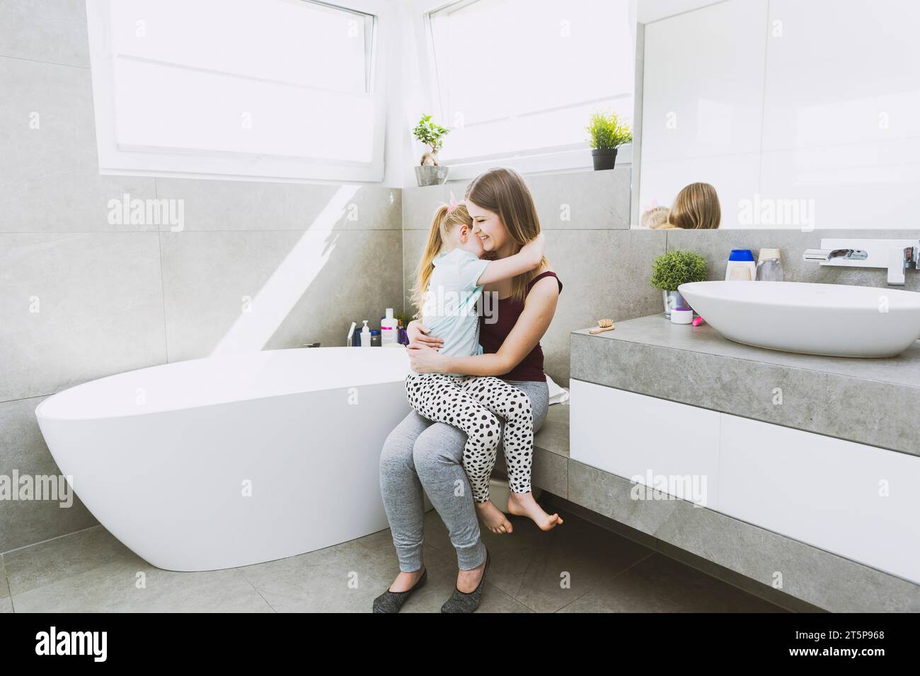 Mother hugging daughter bathroom Stock Photo - Alamy