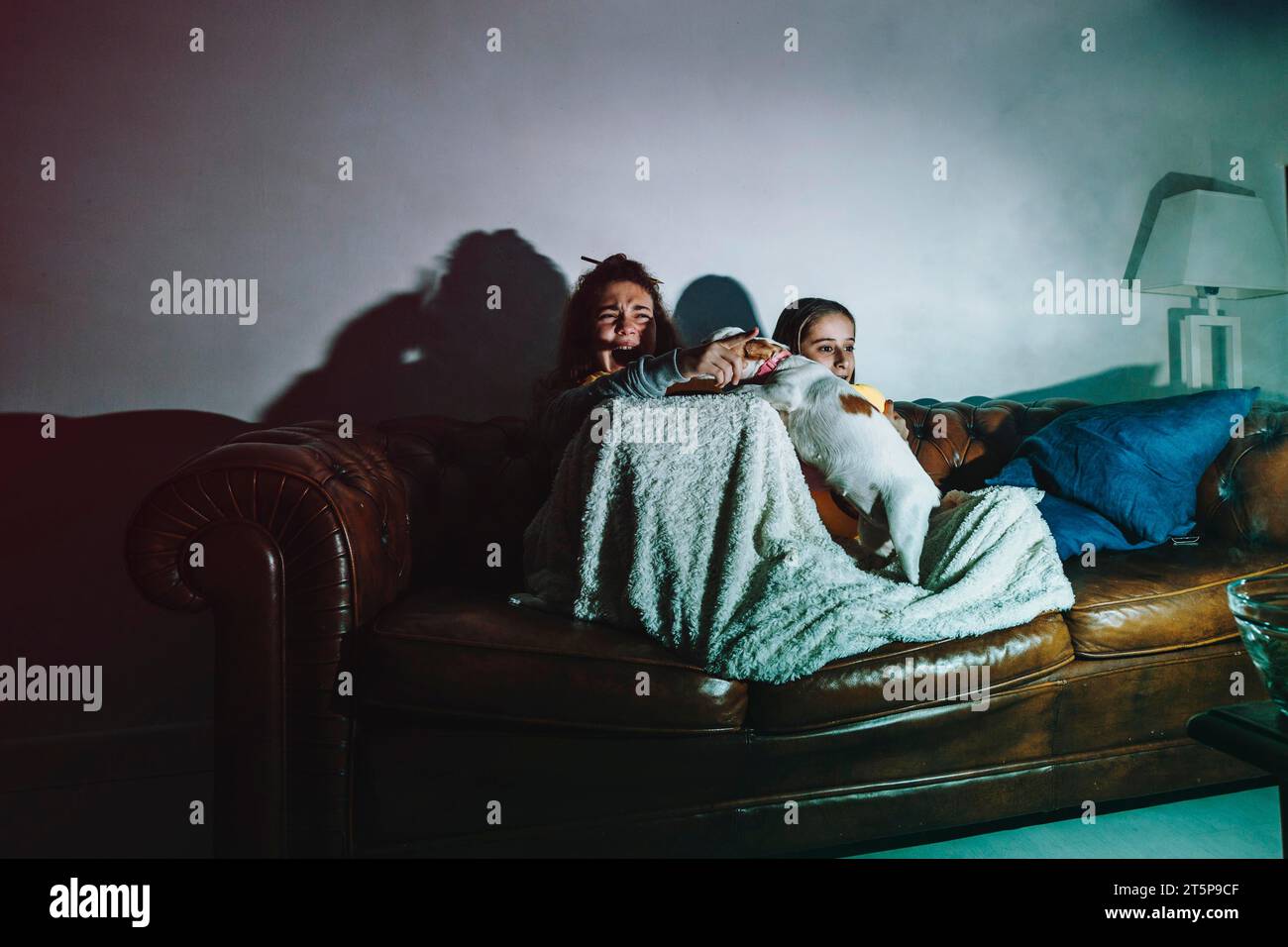 Scared kids watching movie with dog Stock Photo - Alamy
