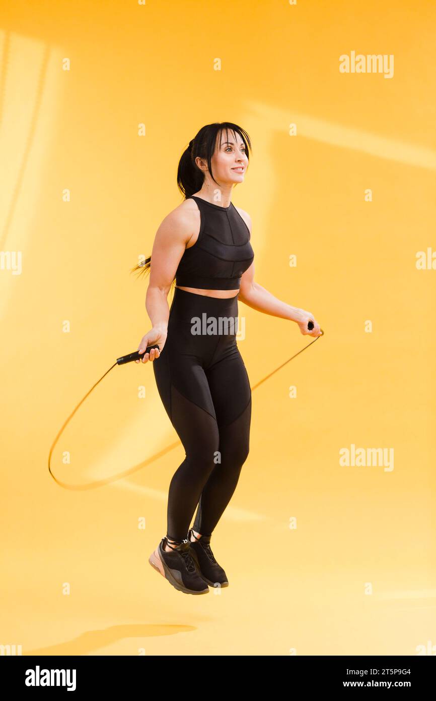 Side view athletic woman gym outfit jumping rope Stock Photo - Alamy