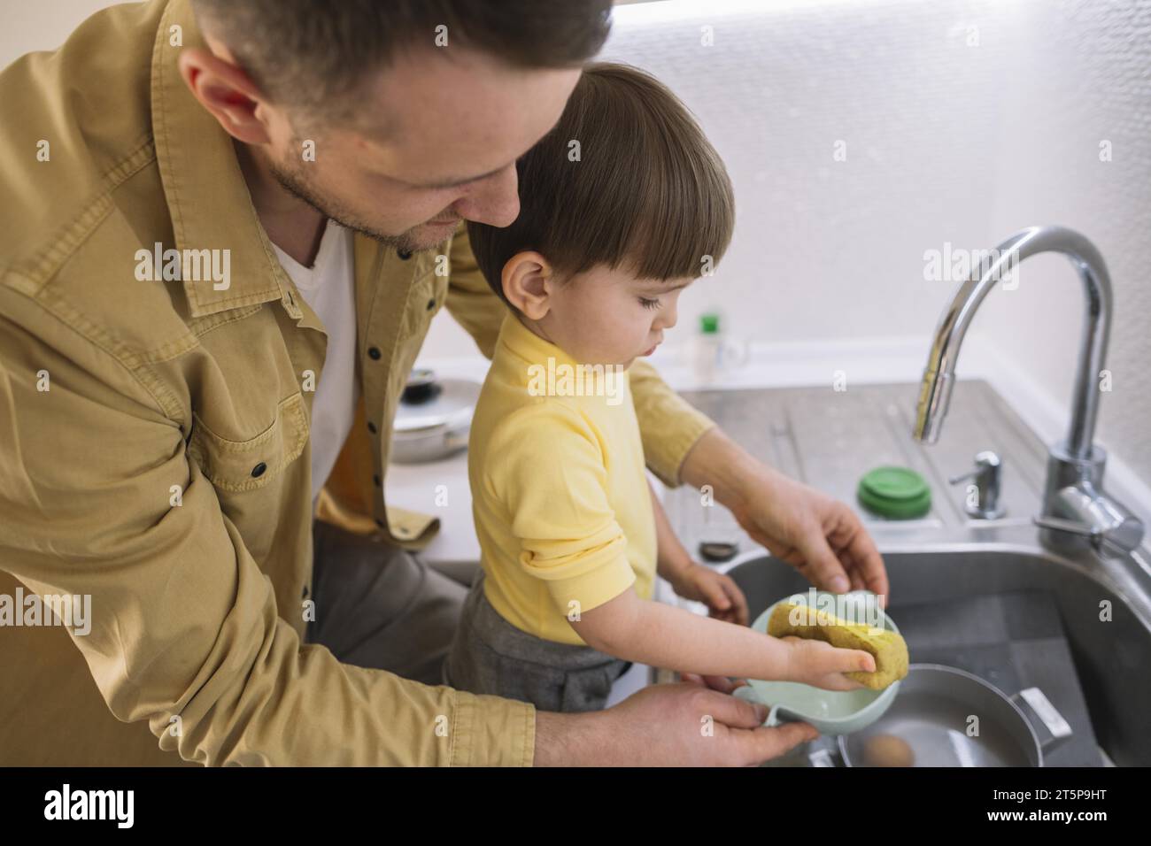 Sideways father son washing dishes Stock Photo - Alamy