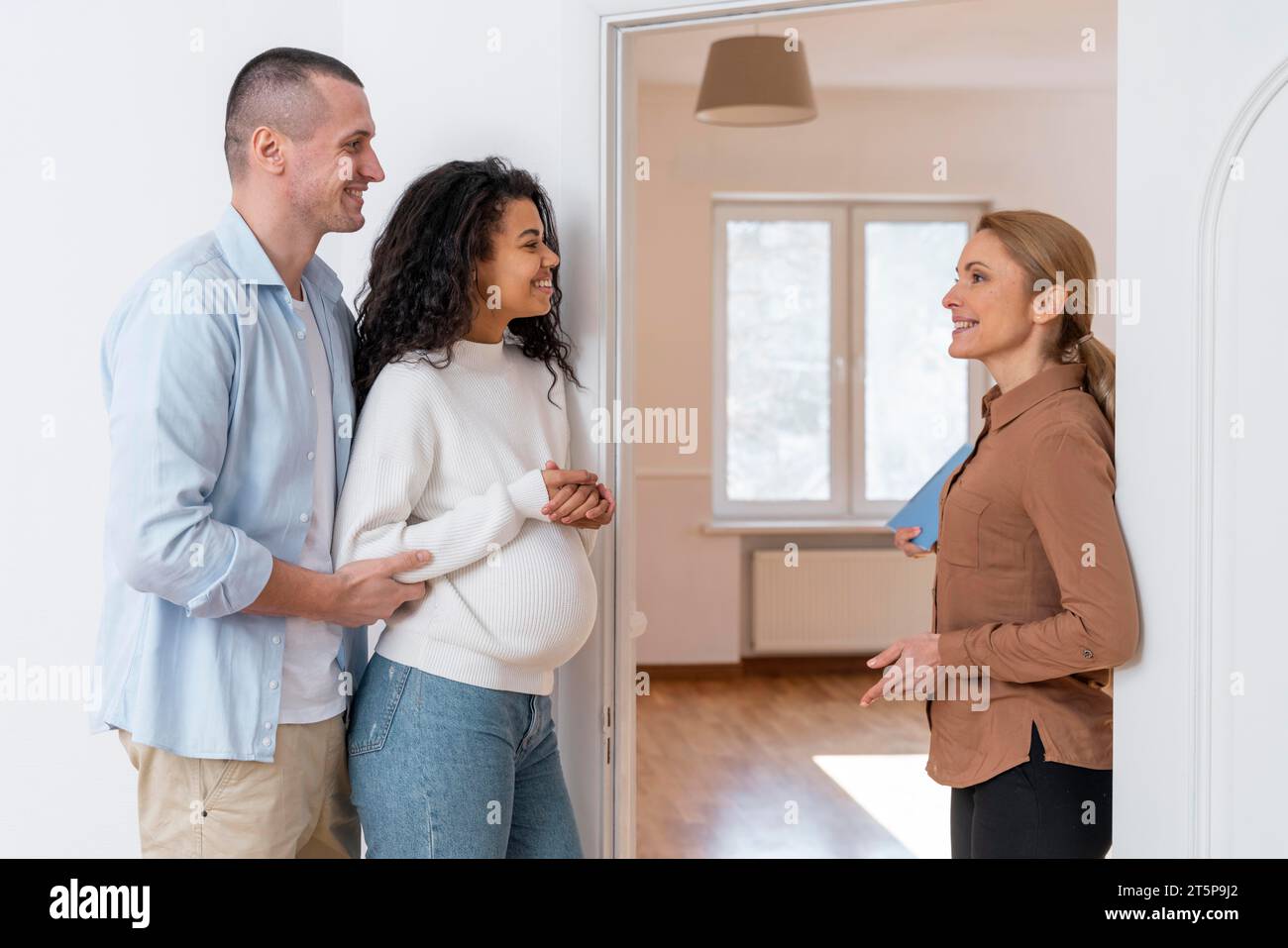 Side view realtor inviting couple see new house Stock Photo - Alamy