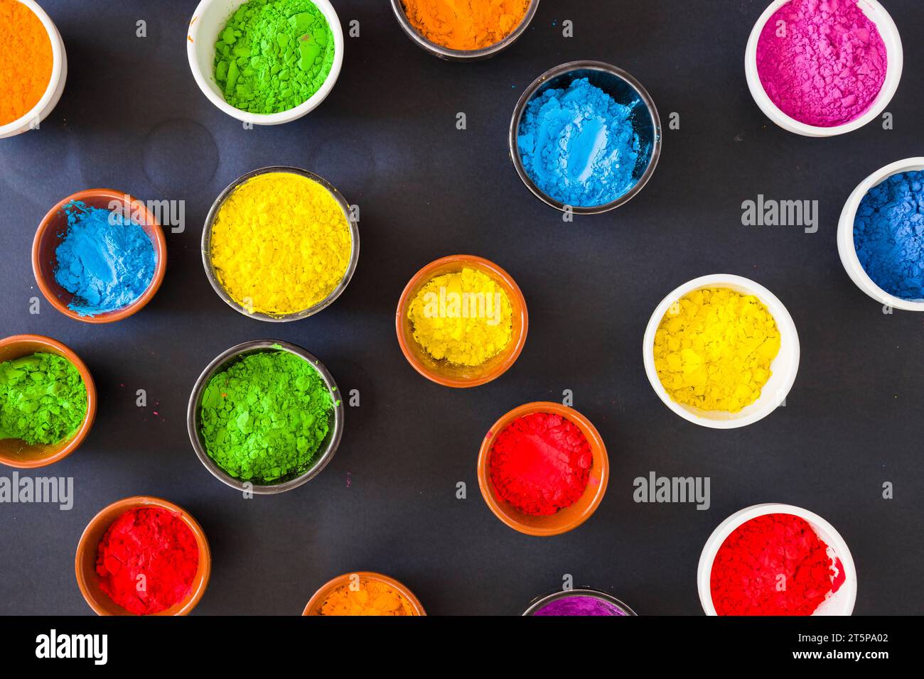 Various holi color powder bowl black background Stock Photo - Alamy