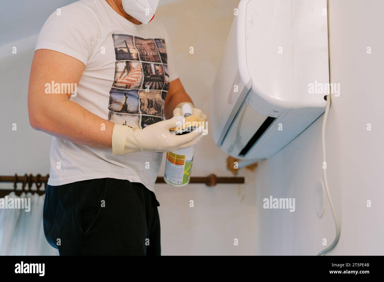 Cleaner in gloves wetting sponge with anti-mold solution Stock Photo ...