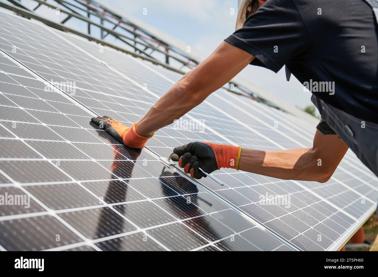 Close up of man hands in work gloves mounting photovoltaic solar panels ...