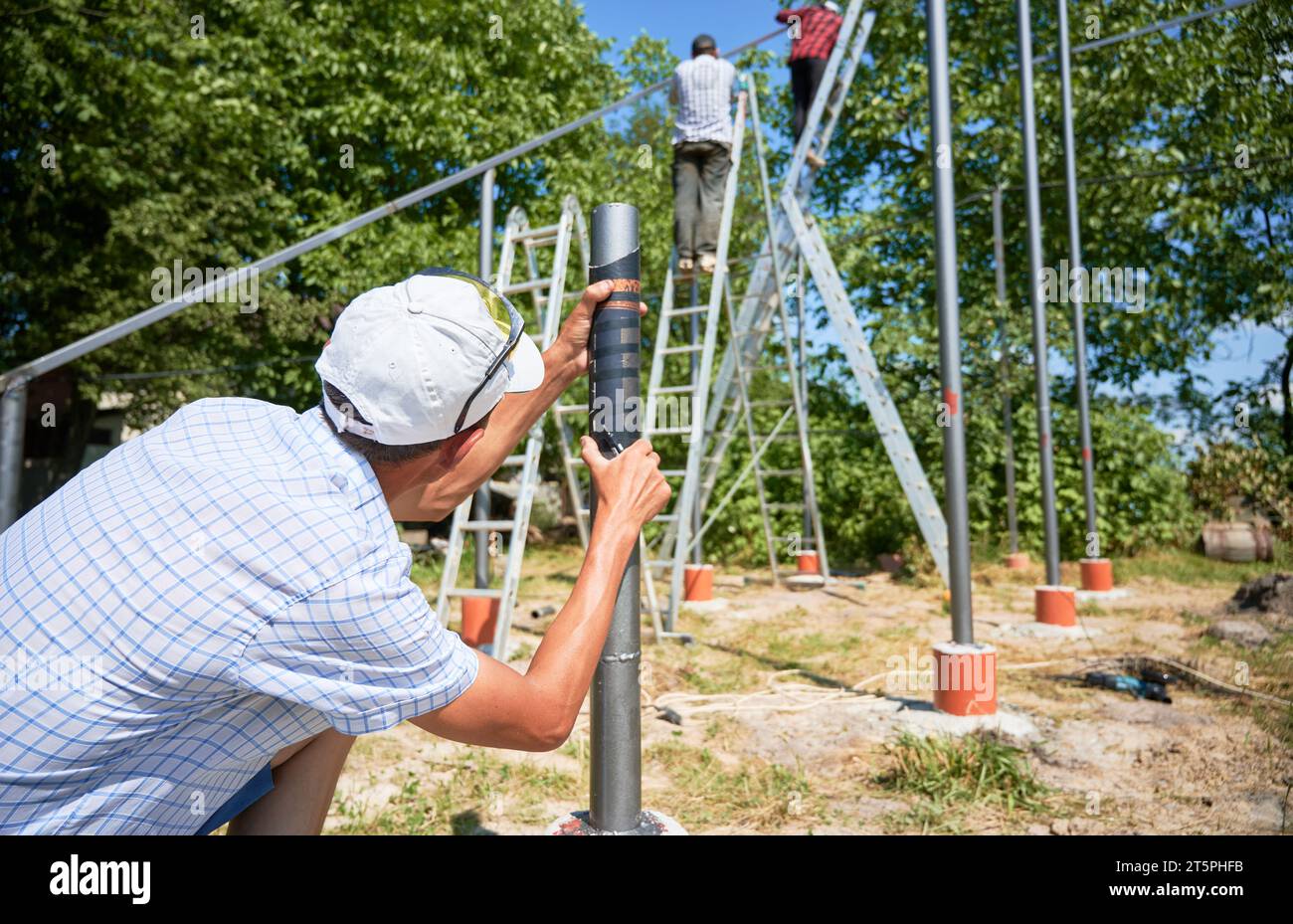 Man solar installer drawing line on meatal tube with marker pen. Male worker marking supporting ...