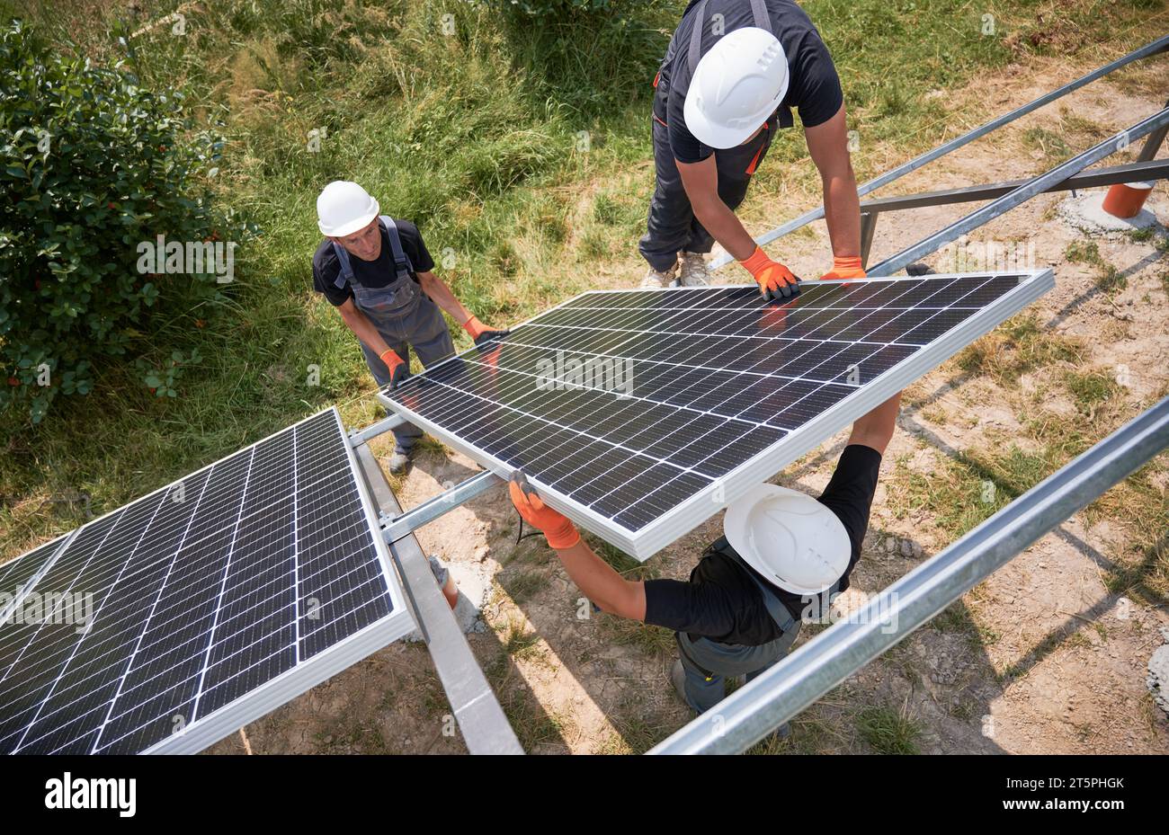 Male workers installing photovoltaic solar panel system outdoors. Men ...