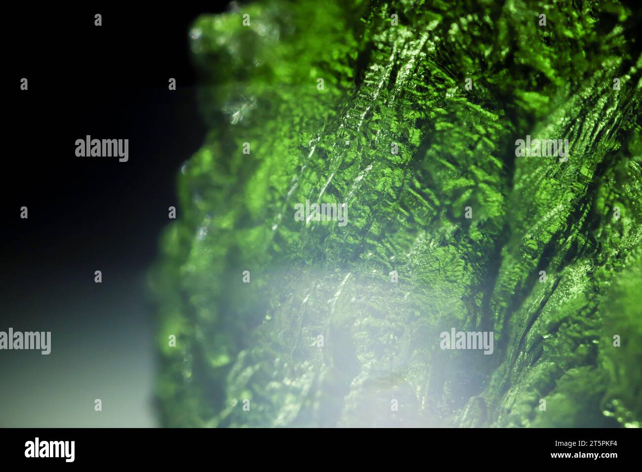 Green glass texture. Moldavite tektite gemstone close up. Lens flare ...