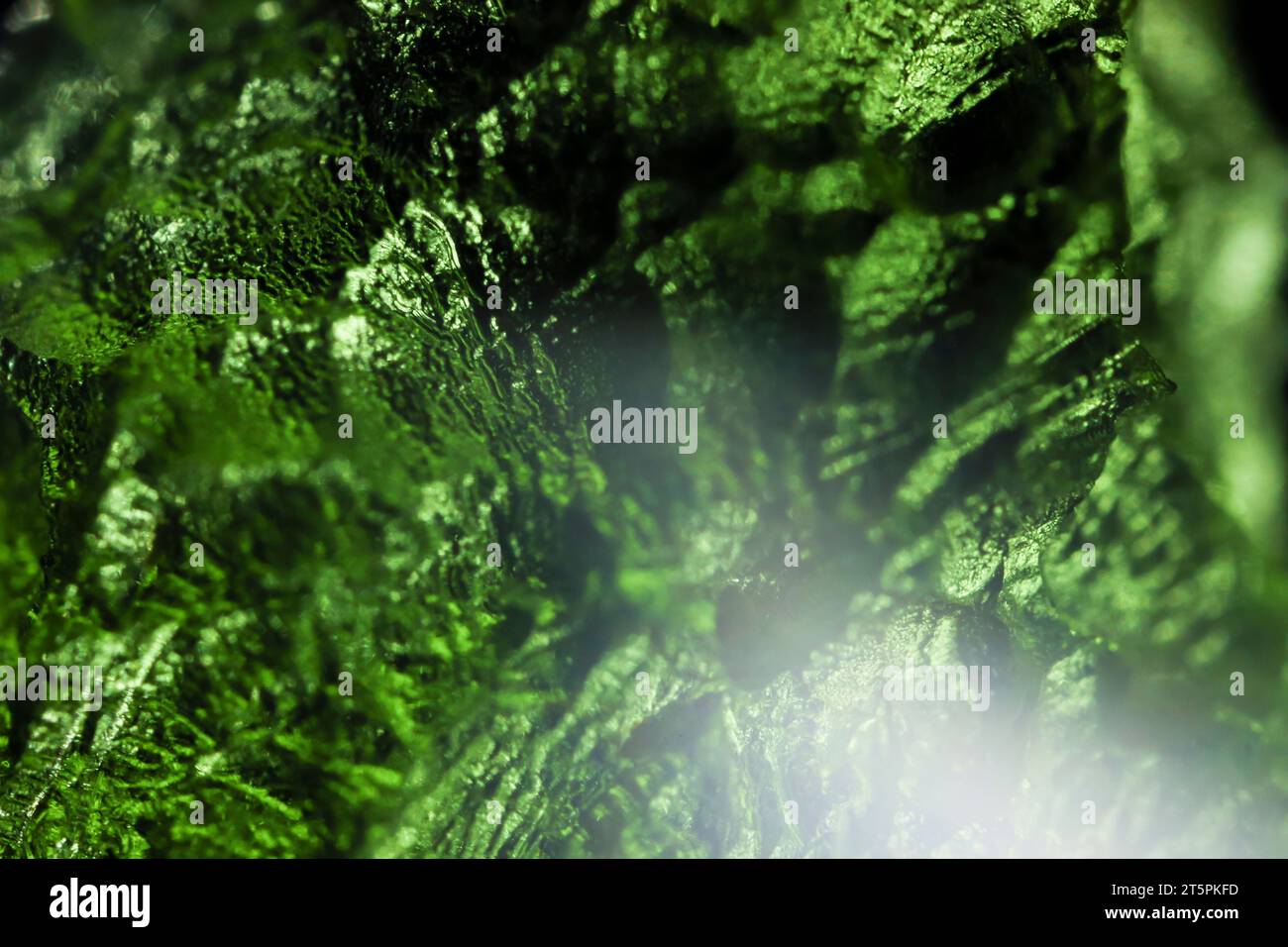 Green glass texture. Moldavite tektite gemstone close up. Lens flare ...