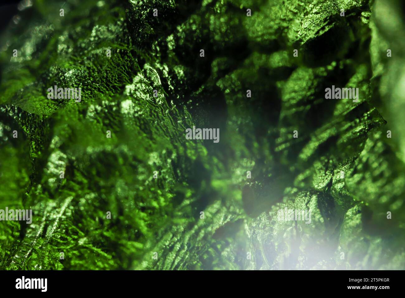 Green glass texture. Moldavite tektite gemstone close up. Lens flare ...
