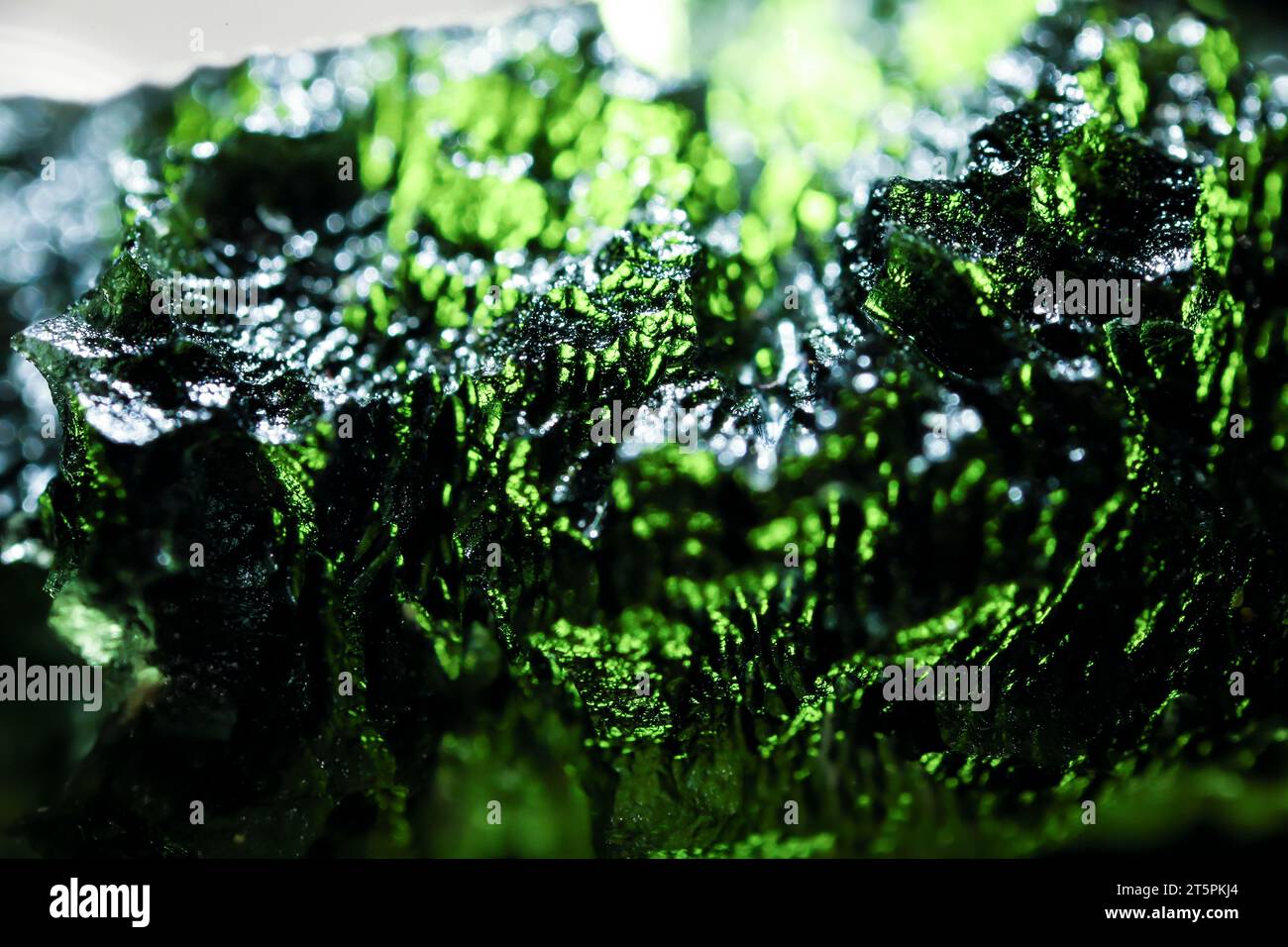 Green gemstone texture. Moldavite tektite close up. Rough surface ...