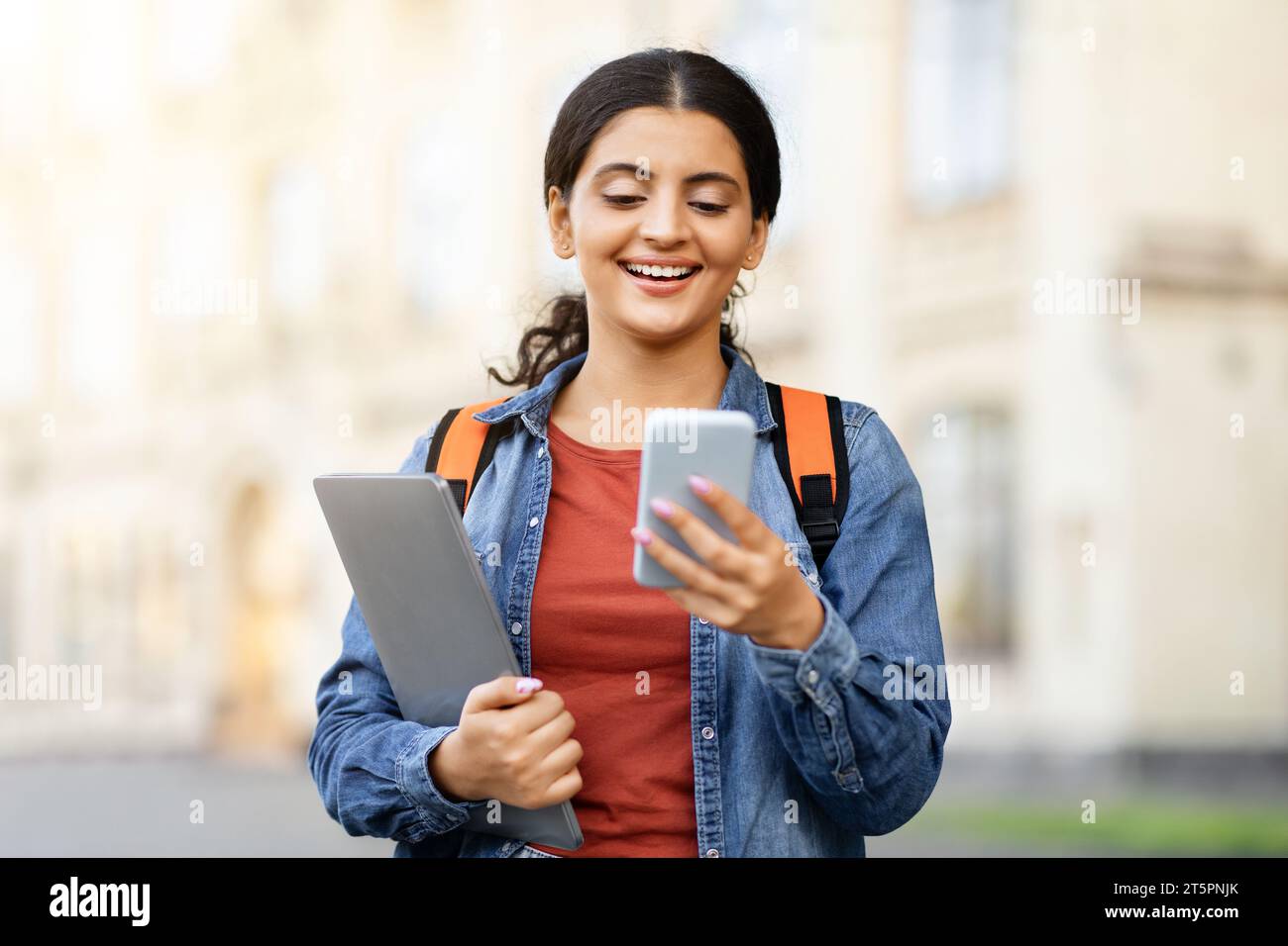 Young indian woman student texting on smartphone at campus Stock Photo ...