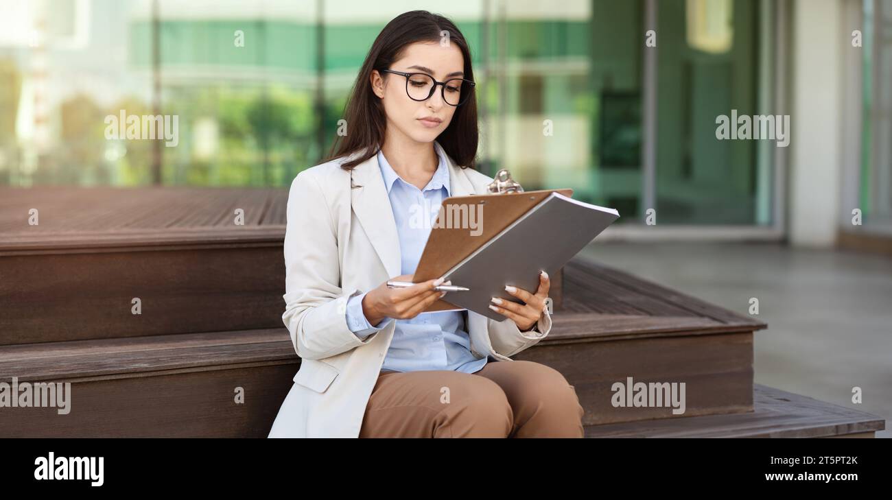 Focused serious pretty young woman secretary manager in suit with ...