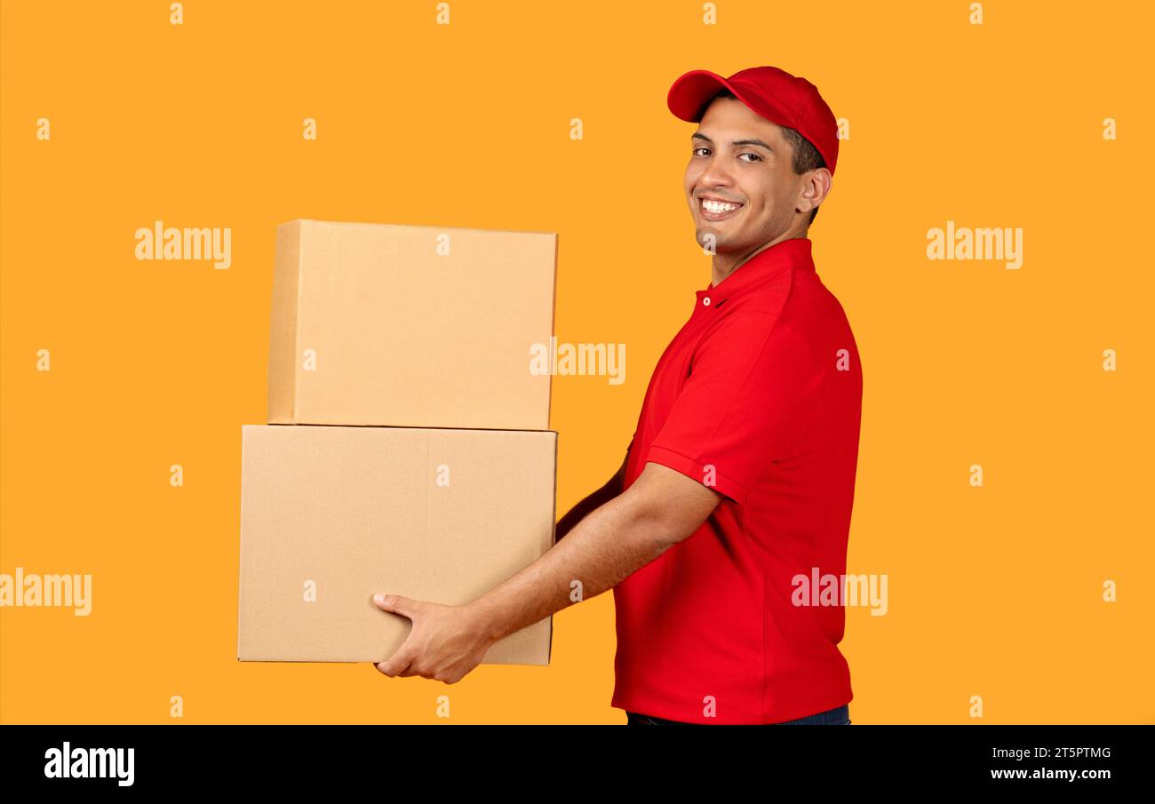 courier worker man carrying two carton boxes stands in studio Stock ...