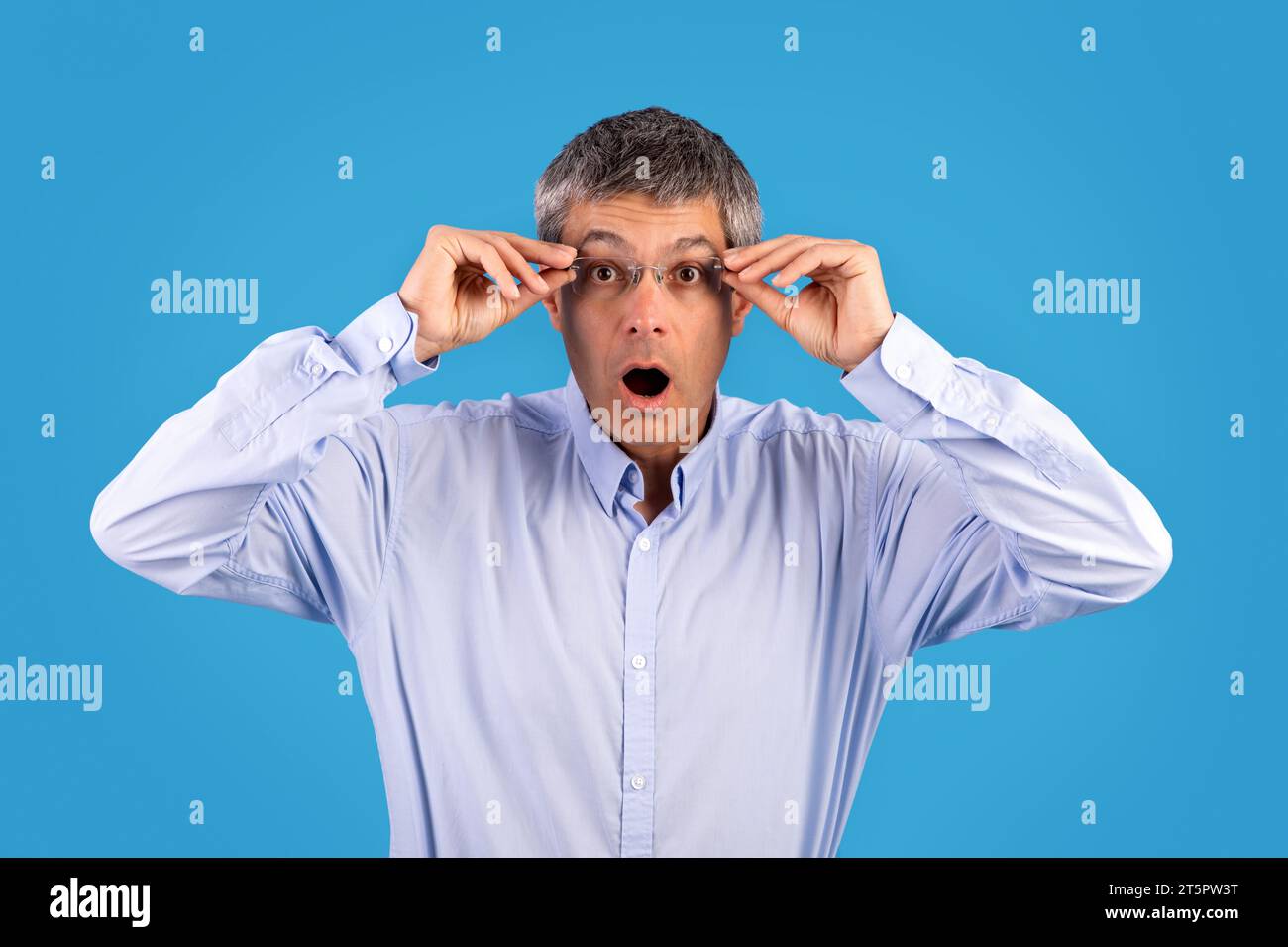 Shocked senior man with clear eyeglasses staring at camera, studio ...