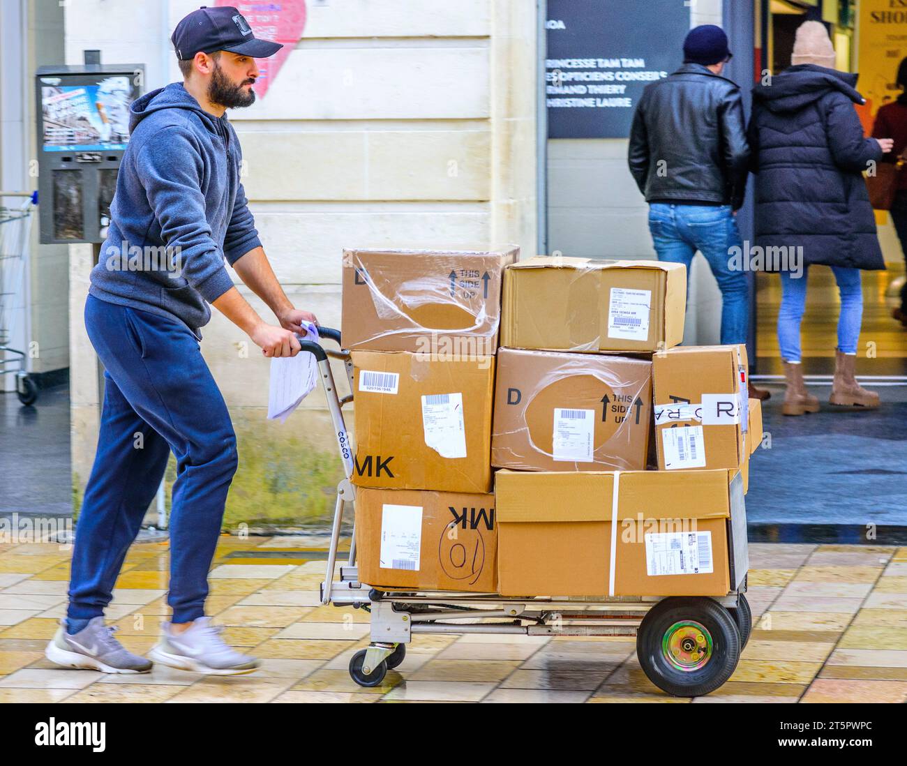 Delivery man pushing trolley parcels hi-res stock photography and ...