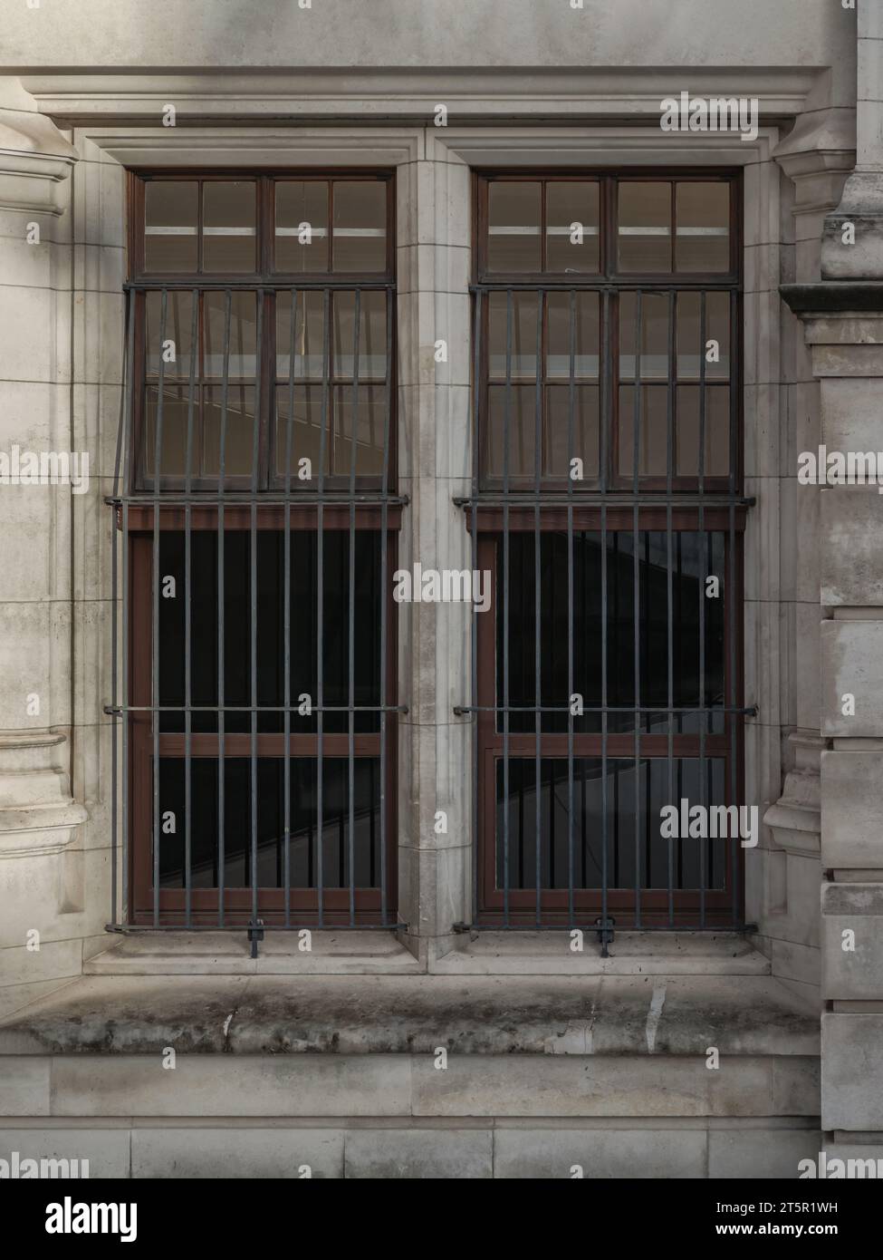 London, UK - Nov 01, 2023 - Glass window frame with behind bars ...