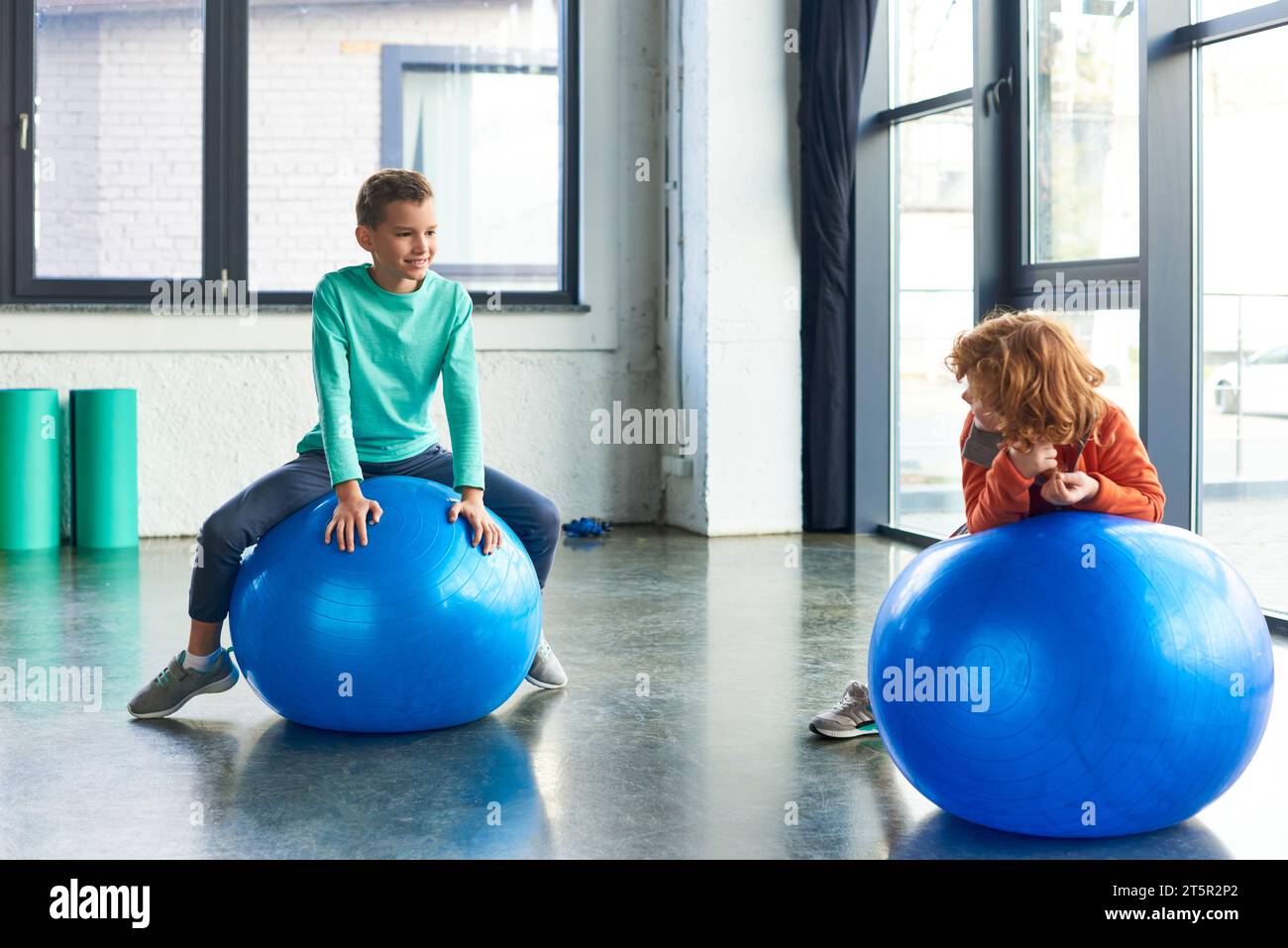 two preadolescent cute boys in sportswear exercising actively on ...