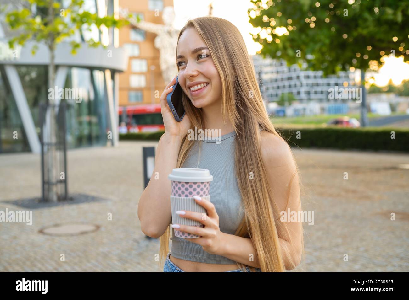 Happy young woman with blonde long loose hair spends time in park ...