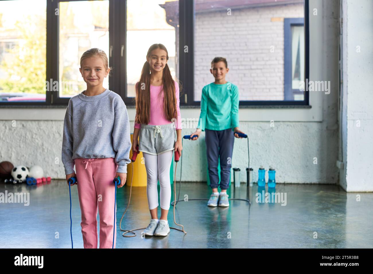 cheerful little cute boy and girls smiling joyfully at camera and ...
