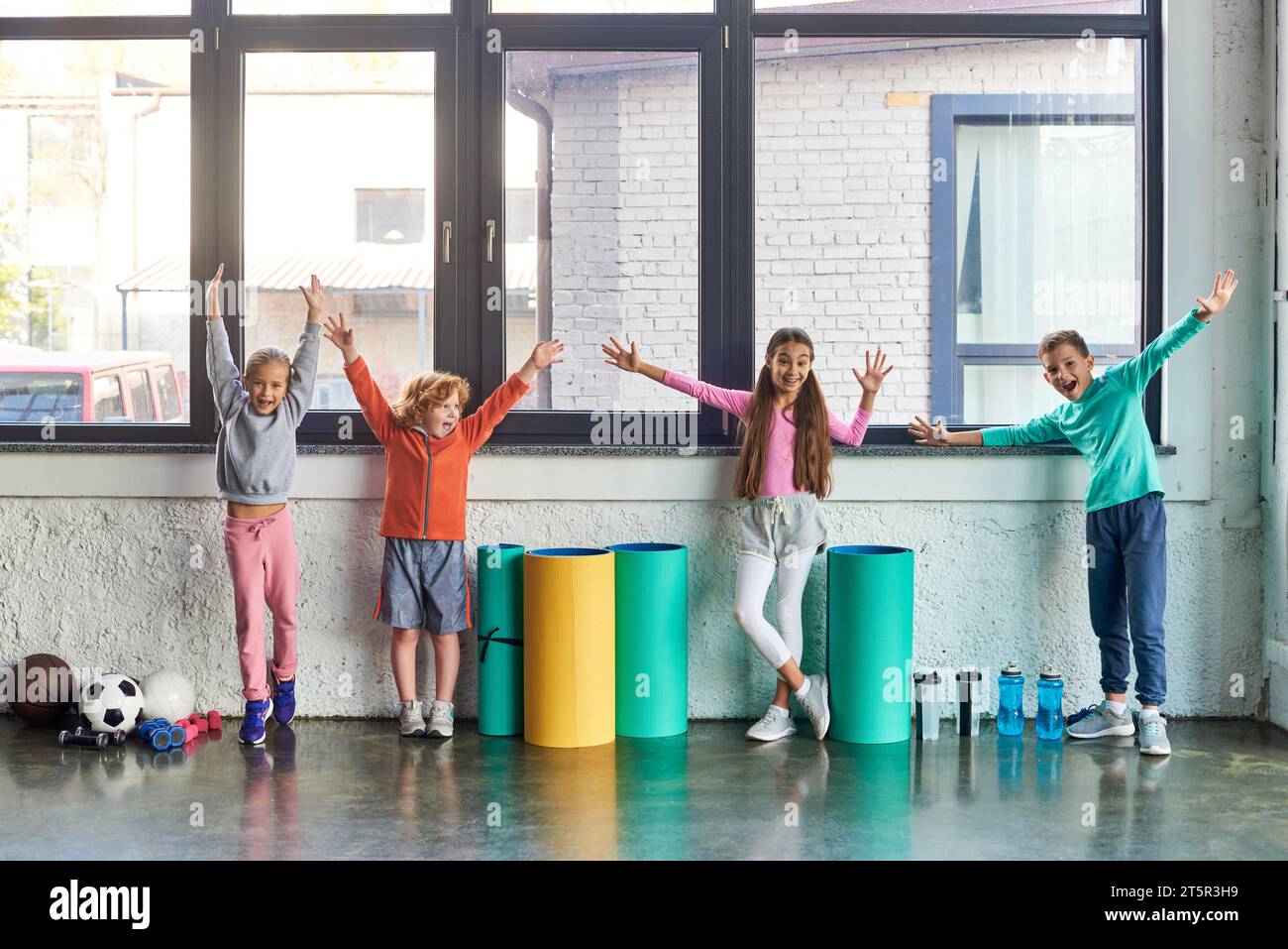 four cute preadolescent children in sportswear having good time and ...