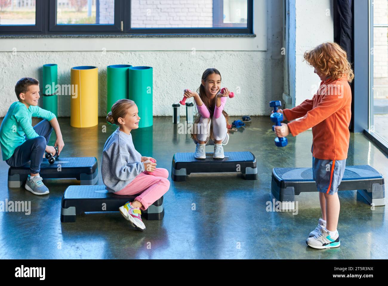 preadolescent happy children on fitness steppers with dumbbells smiling ...
