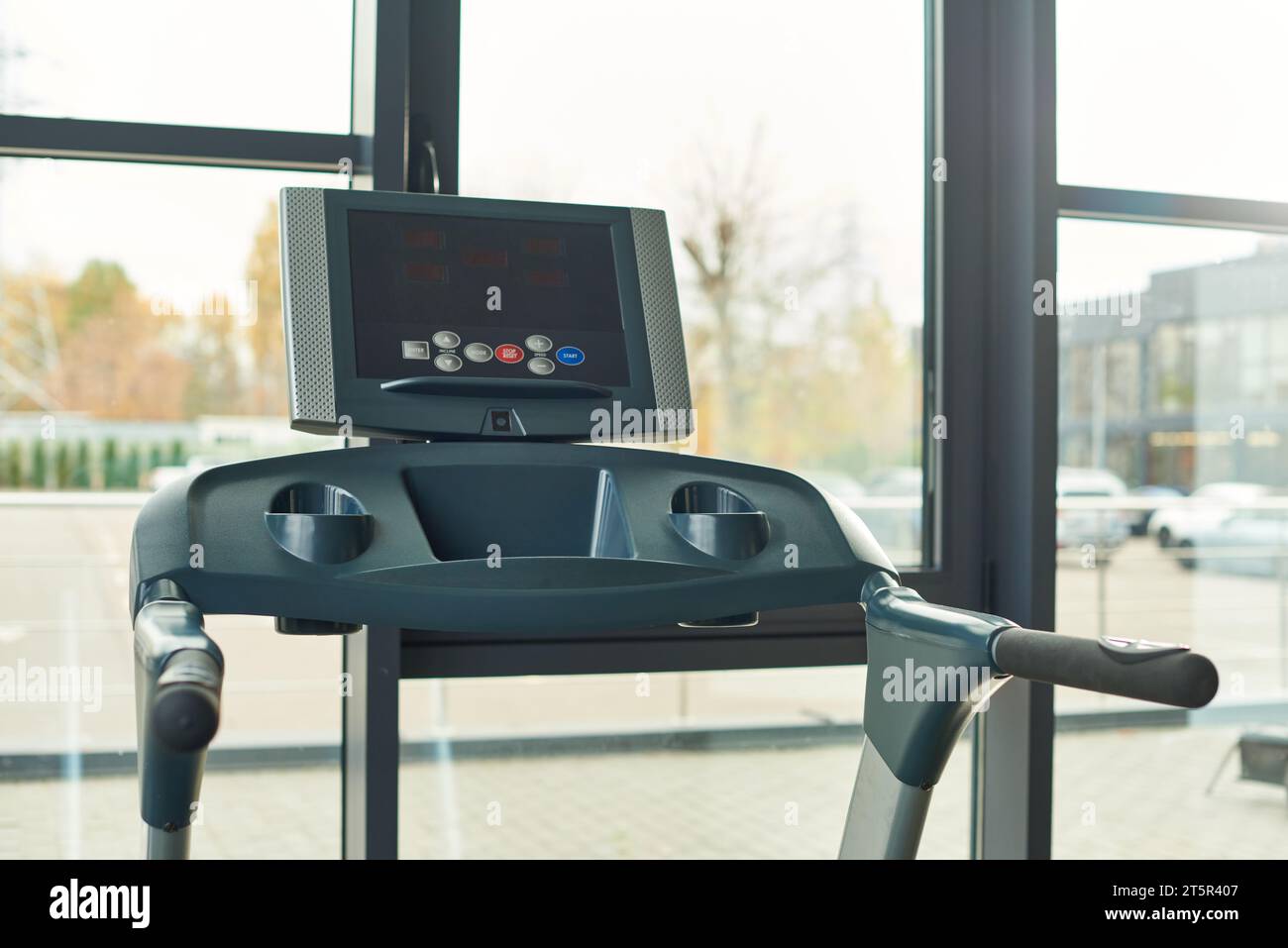 photo of black modern treadmill indoors in gym with window on backdrop ...