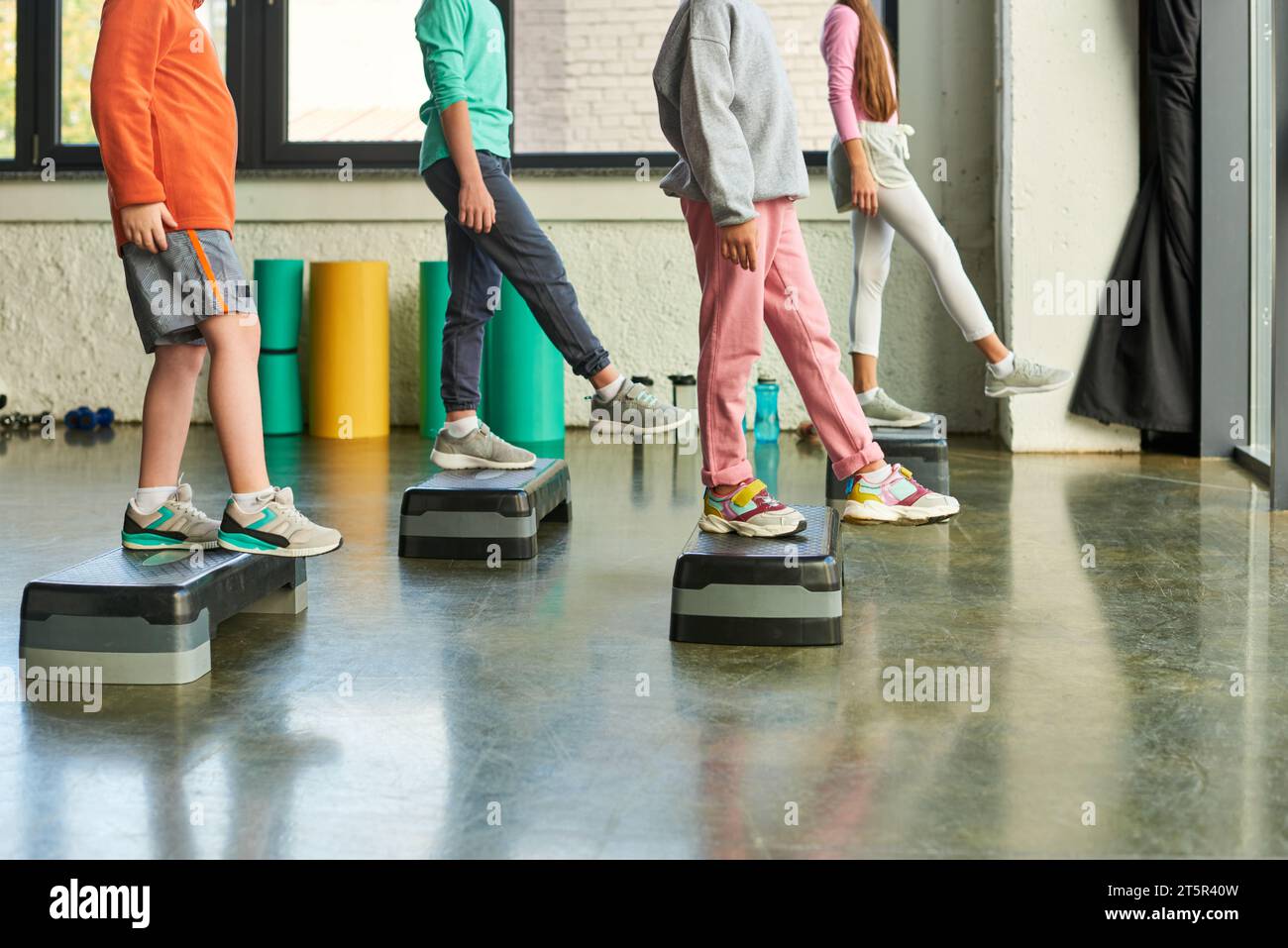 cropped view of children in sportswear doing exercises on fitness ...