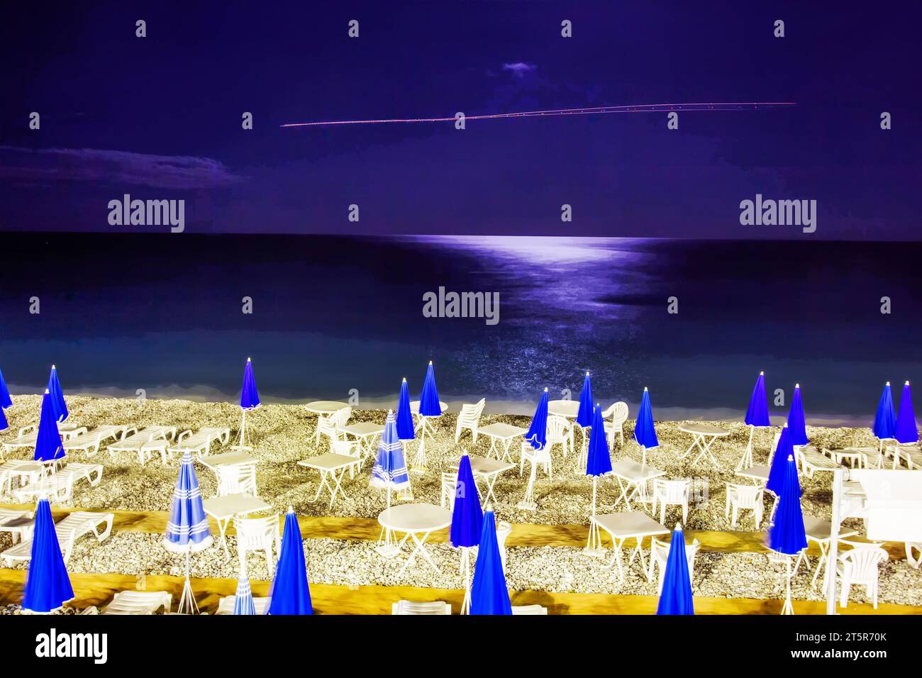 Sunset view of Nice on the beach French Riviera and trace of airplane ...