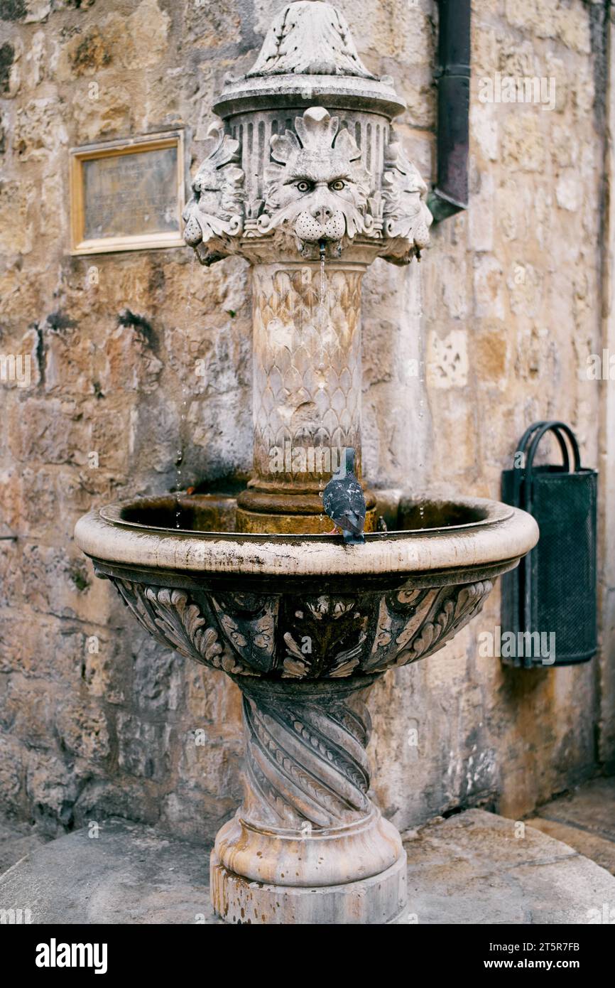 Ancient medieval stone fountain on the corner of the building ...