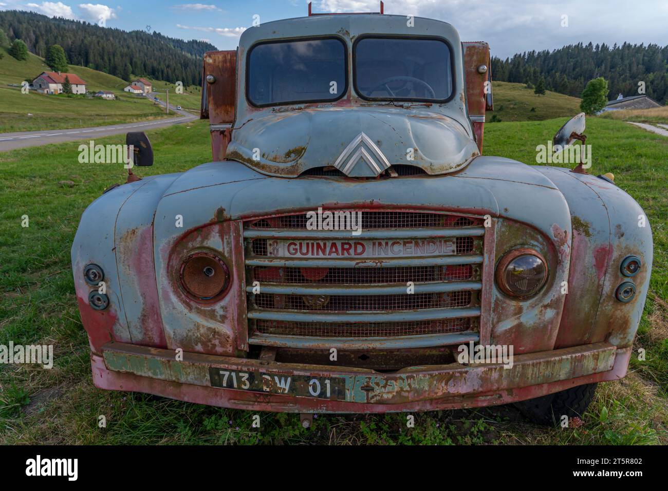 View of an old red and blue rusty fire engine and forest around Stock ...