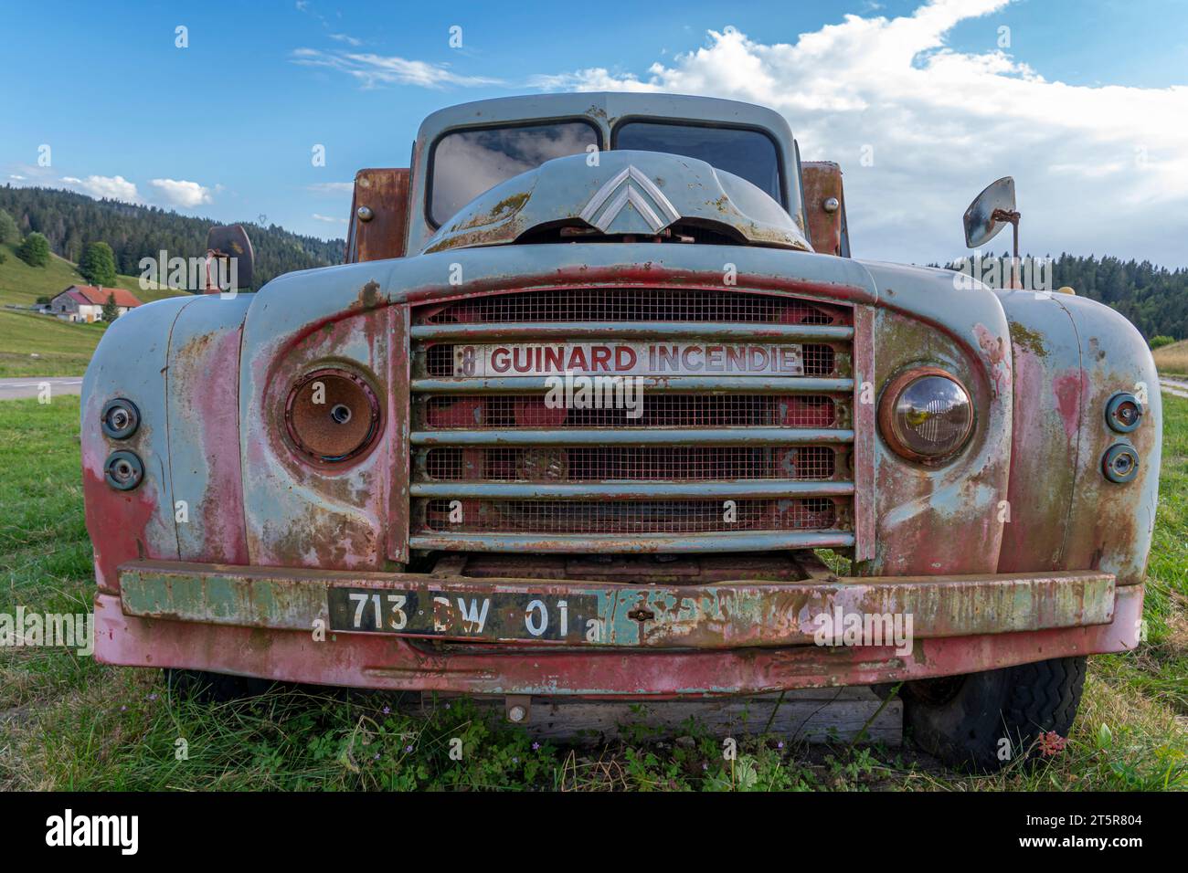 View of an old red and blue rusty fire engine and forest around Stock ...