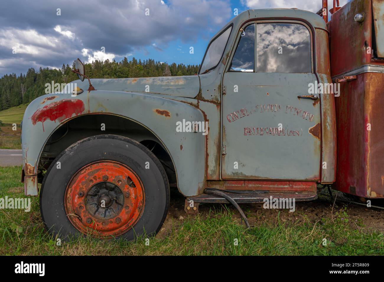 View of an old red and blue rusty fire engine and forest around Stock ...
