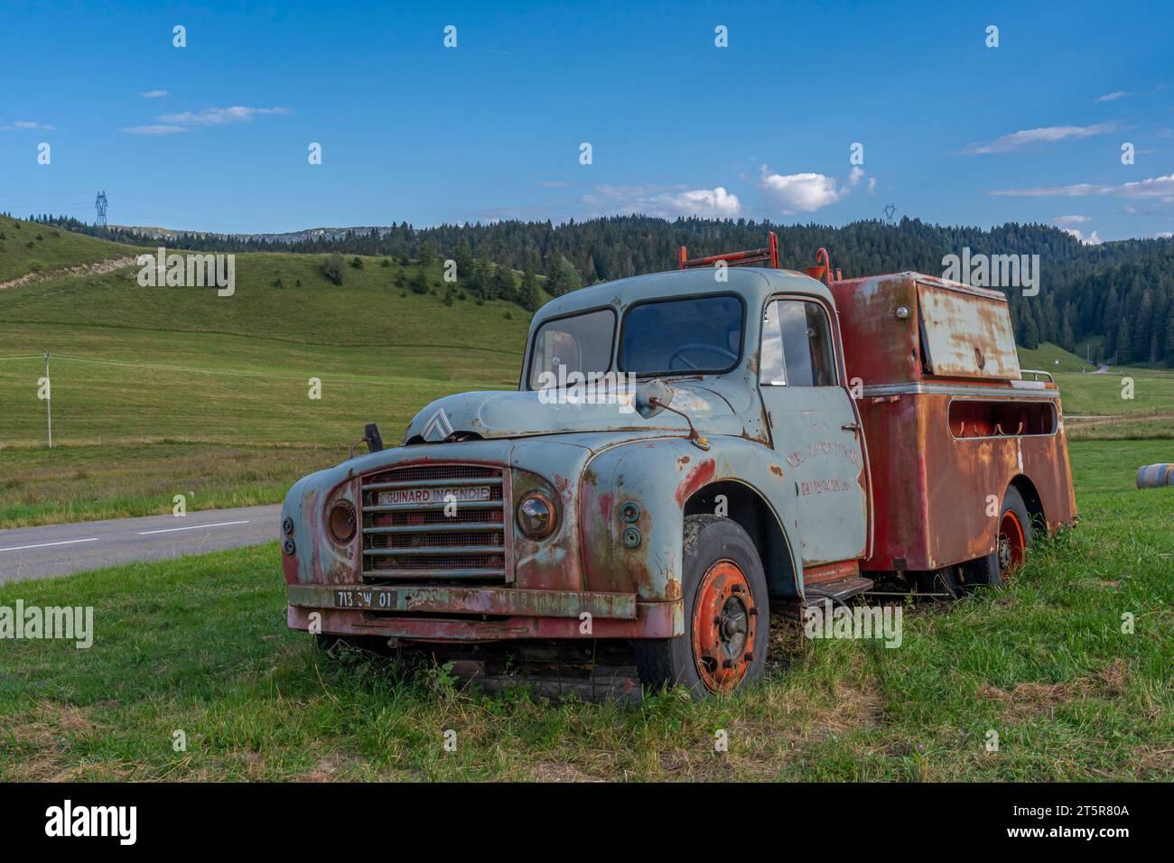 View of an old red and blue rusty fire engine and forest around Stock ...