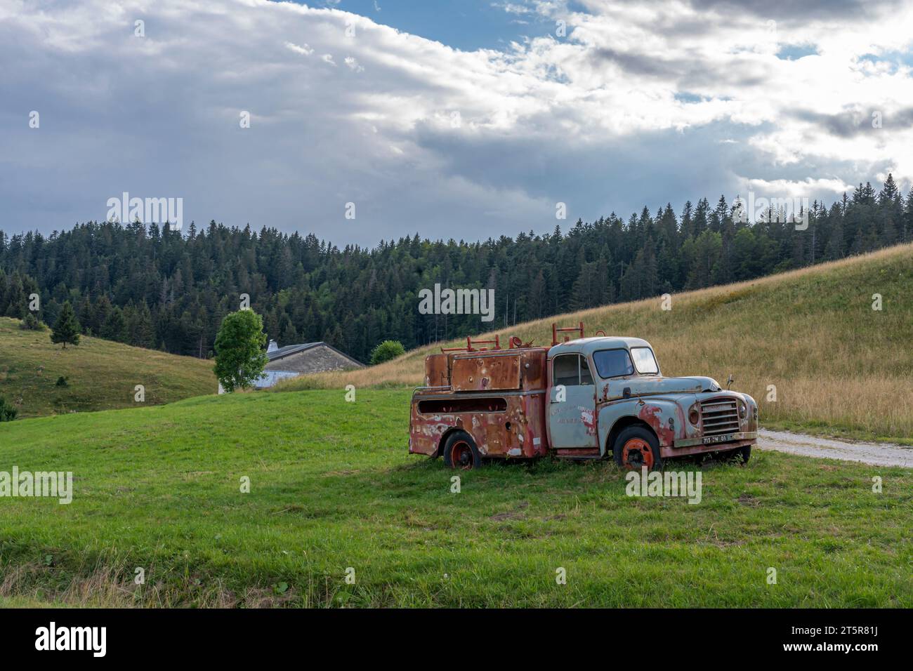 View of an old red and blue rusty fire engine and forest around Stock ...