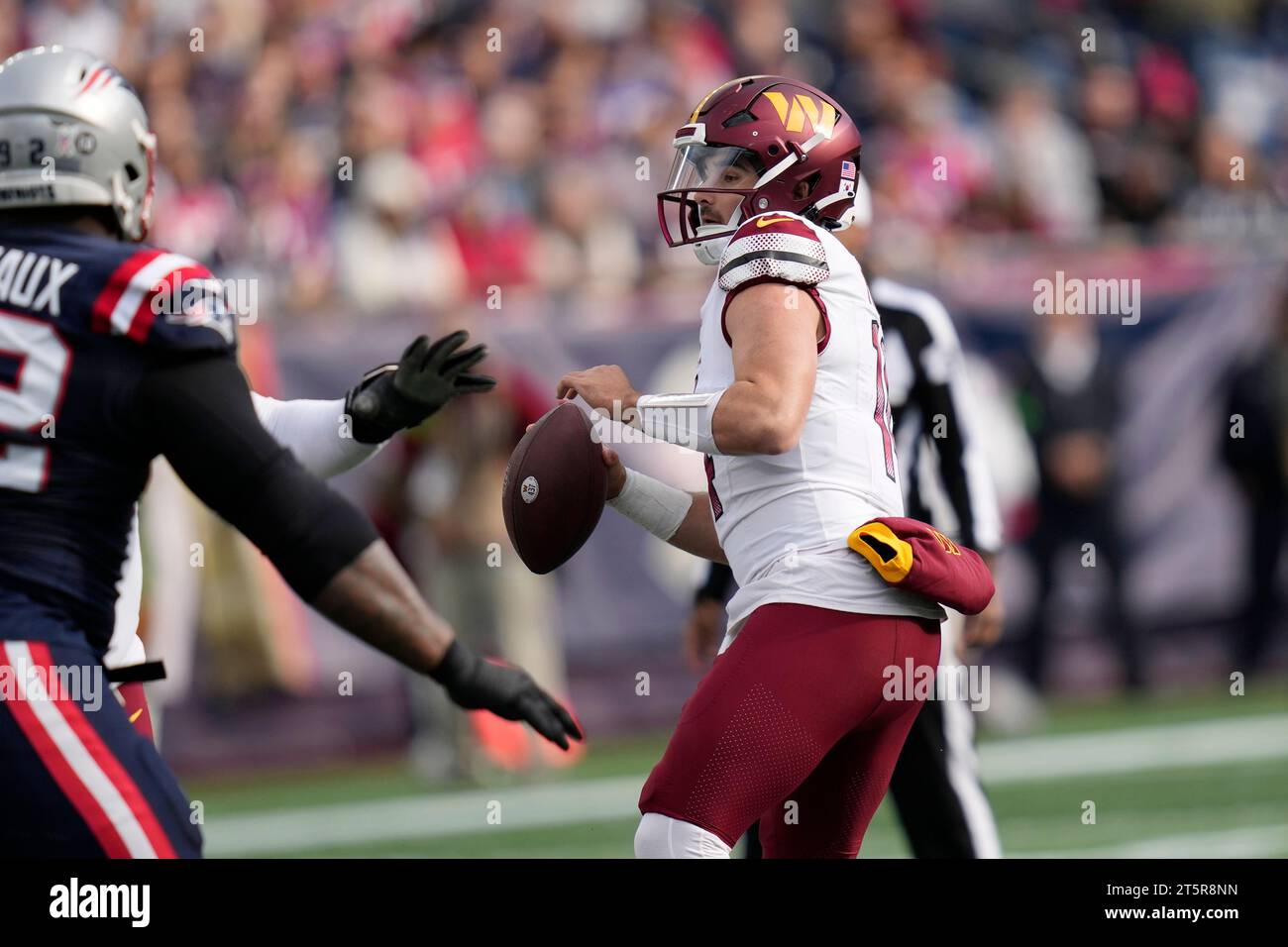 Washington Commanders quarterback Sam Howell, right, looks to throw ...
