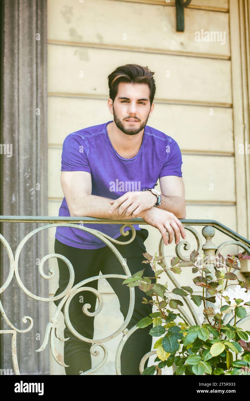 A man leaning on a railing with his arms crossed. Photo of a confident ...