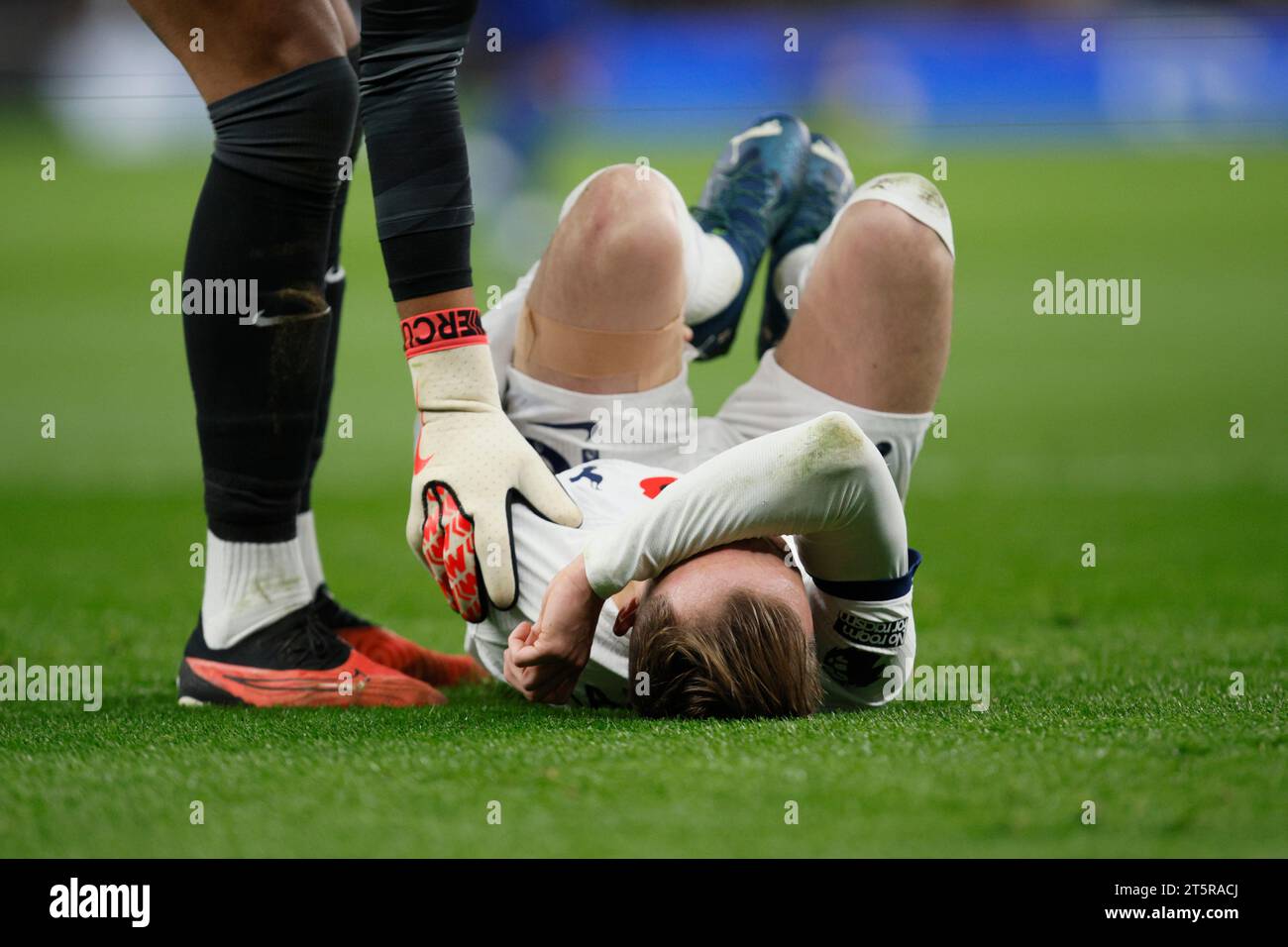 Tottenham's James Maddison lies on the pitch in pain during the English ...