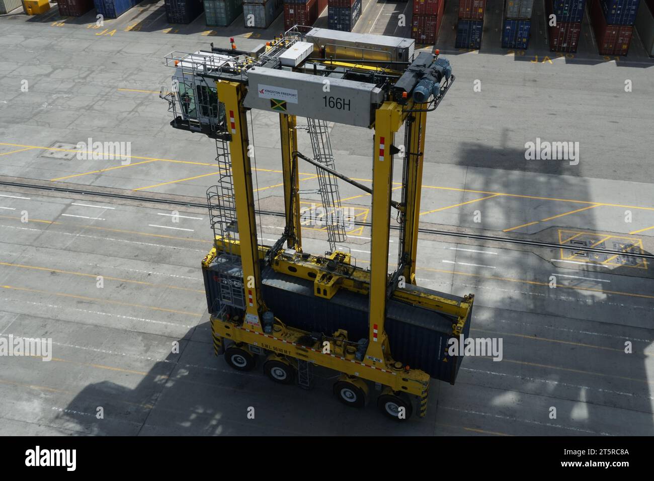 A yellow straddle carrier with loaded blue container in Kingston ...