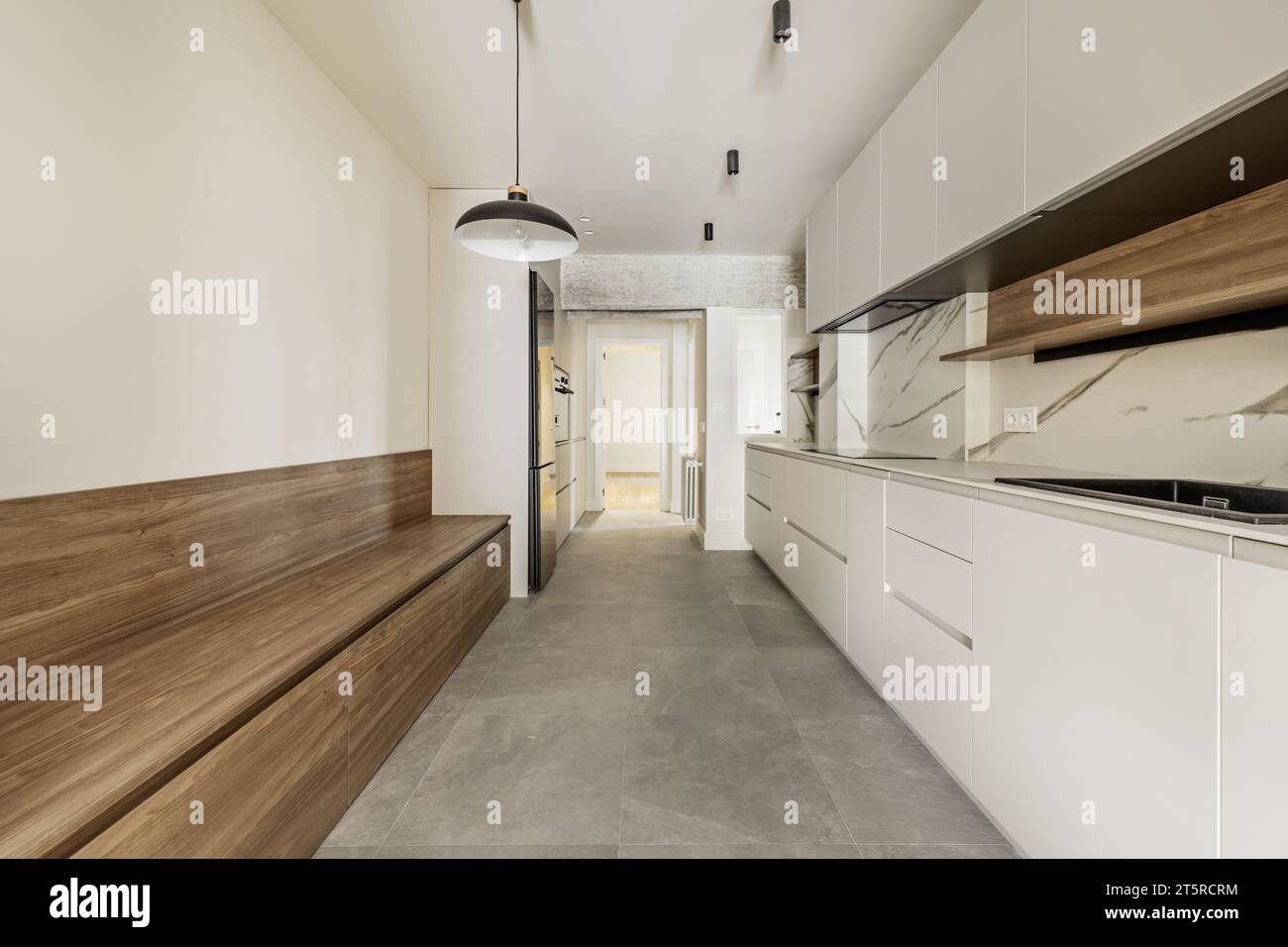 Newly installed narrow walk-through kitchen with white furniture ...